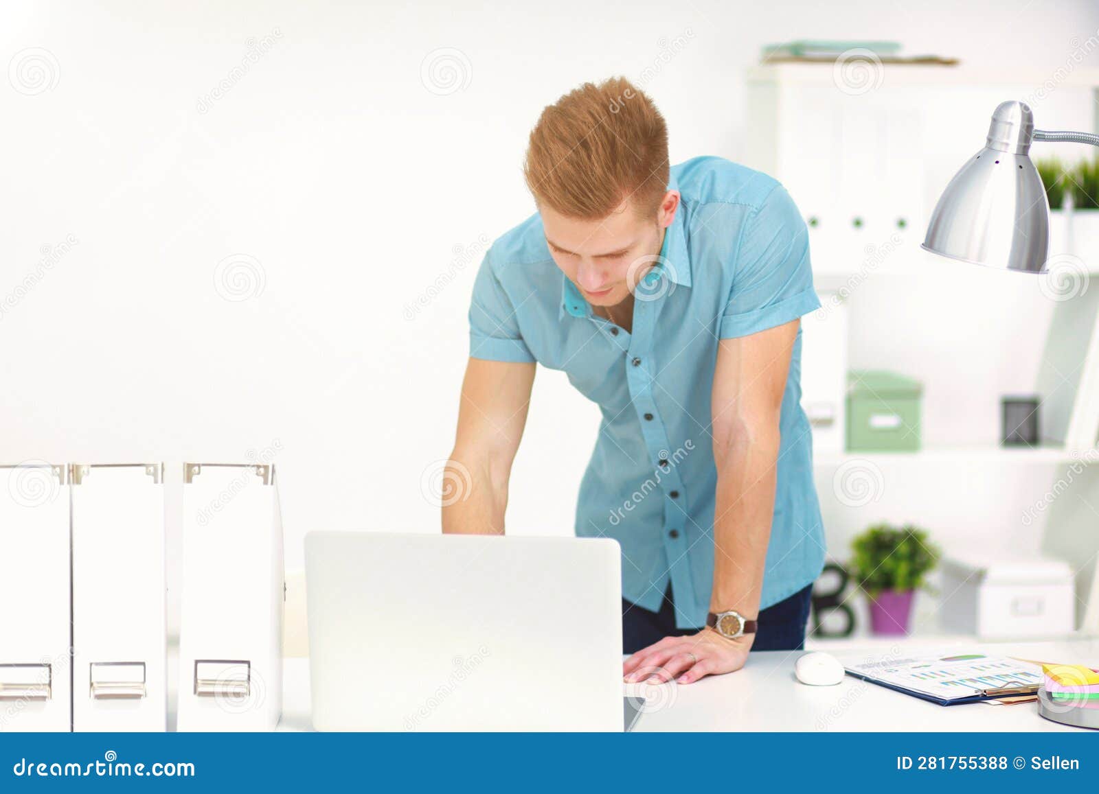 Businessman Standing at Table Working with Laptop Computer, Leaning on ...