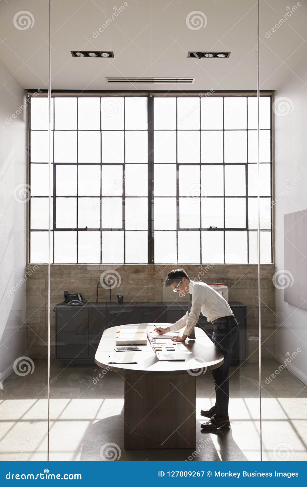 Businessman Stands Working Alone in an Office, Vertical Stock Image ...