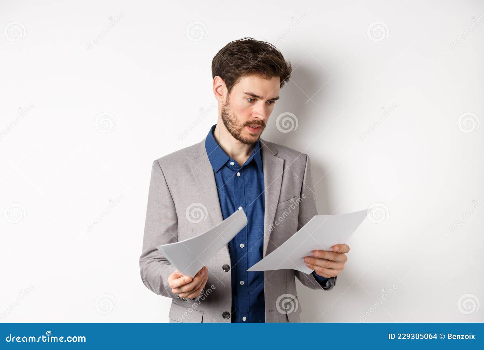 Businessman in Suit Looking through Papers, Reading Documents at Work ...