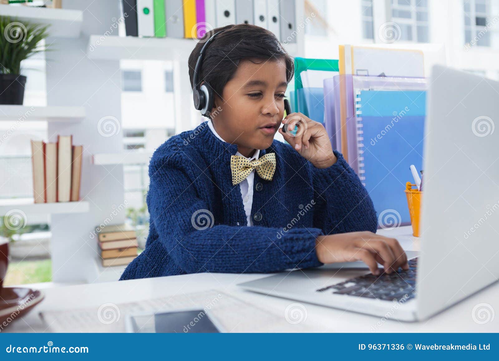 Businessman Talking on Microphone with Head Set while Working on Laptop ...