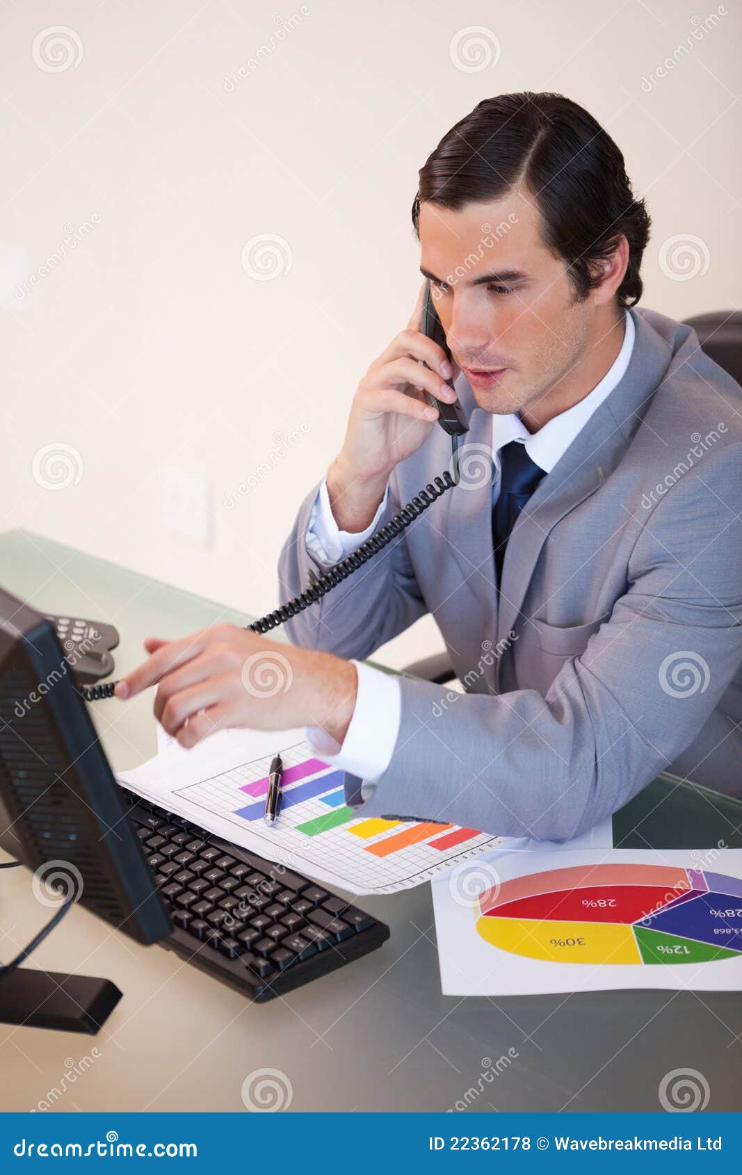 Businessman Talking on the Phone while Working on Statistics Stock ...