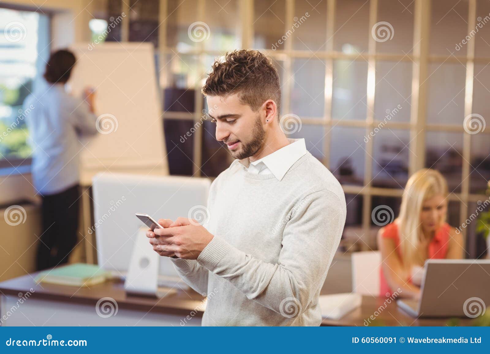 Businessman Texting on Phone with Colleagues Working in Office Stock ...