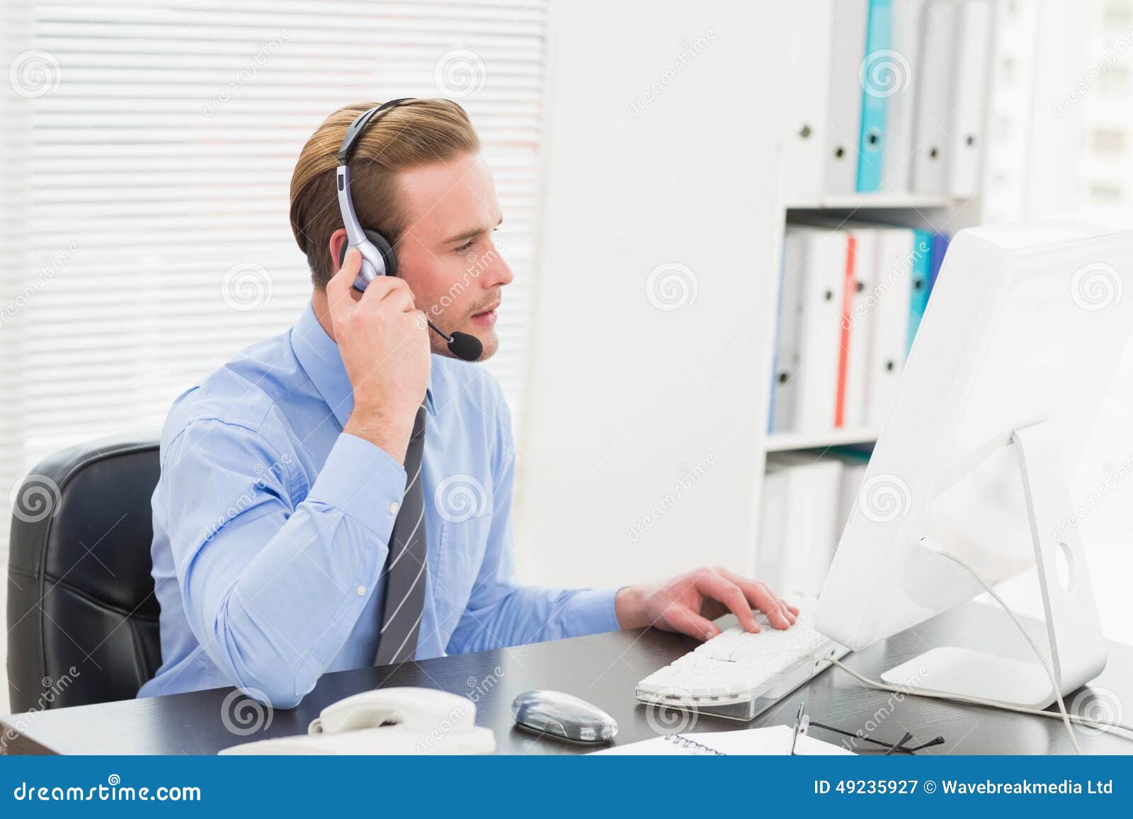 Businessman Typing at Computer while Speaking with Headset Stock Image ...