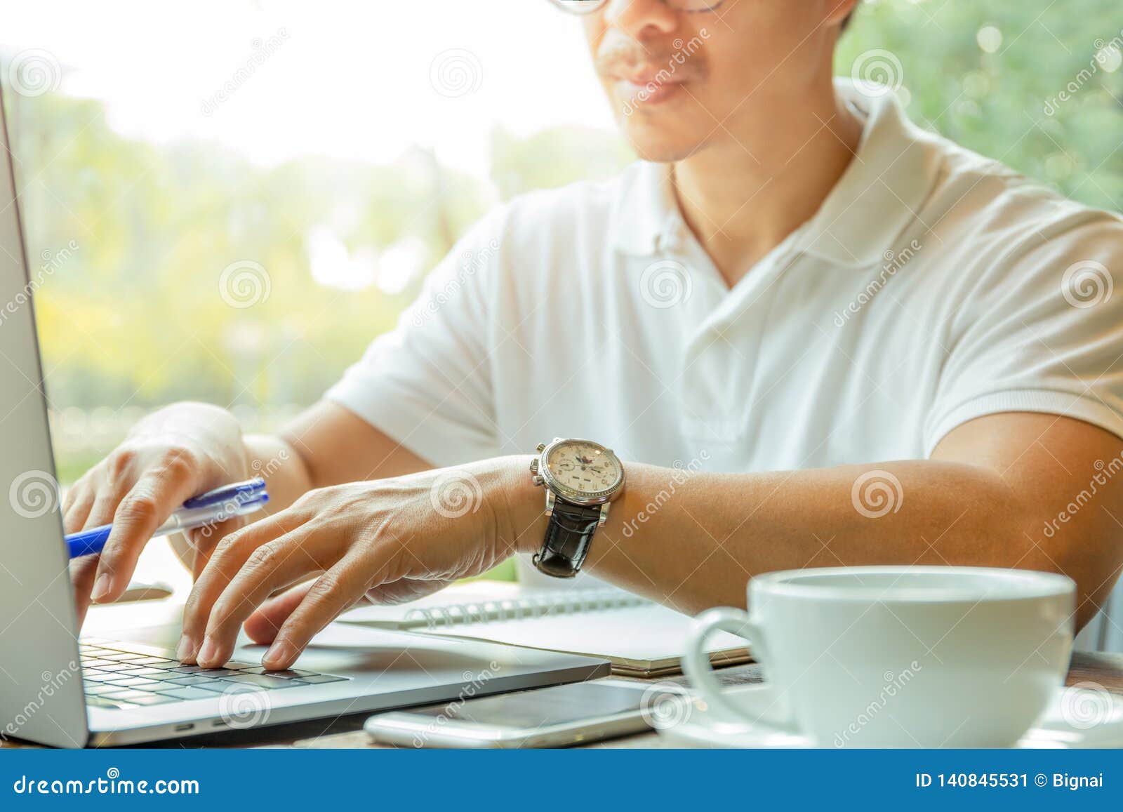 Businessman Typing on Laptop Computer while Sitting in Cafe with Cup of ...