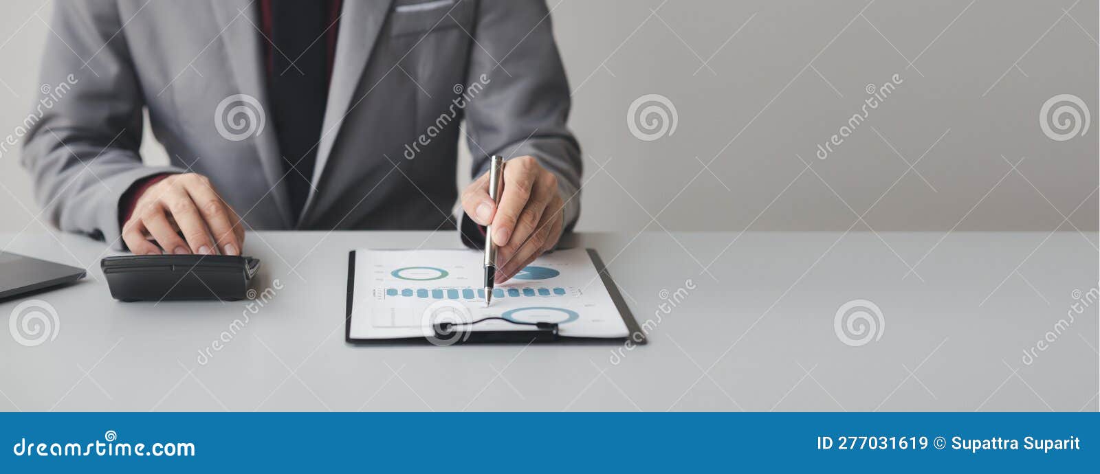 Businessman Using a Calculator To Calculate Numbers on a Company S ...