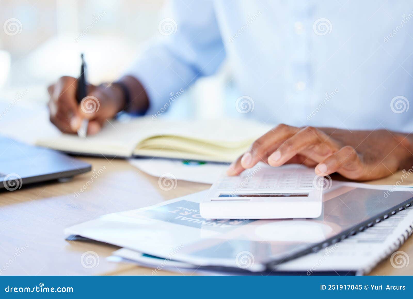 Businessman Using a Calculator and Writing in a Notebook at Work ...