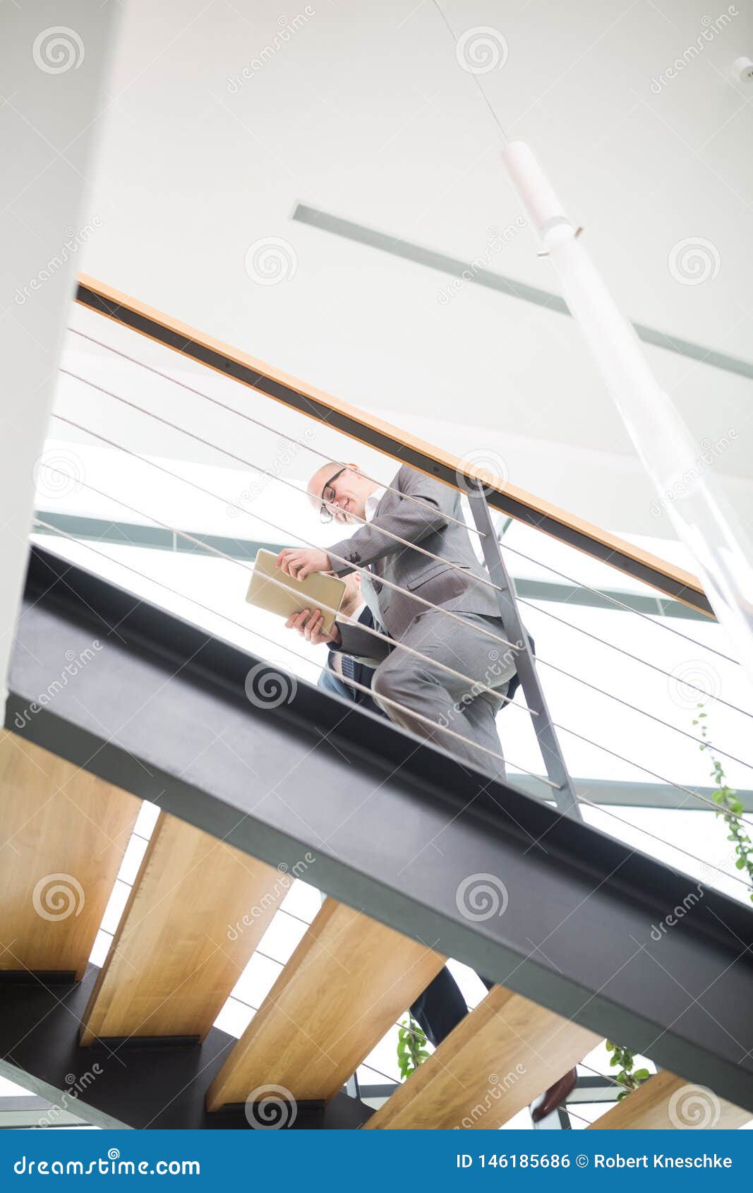 Businessman Using Digital Tablet while Moving Upstairs in Office Stock ... Businessman Using Digital Tablet while Moving Upstairs in Office Stock ...