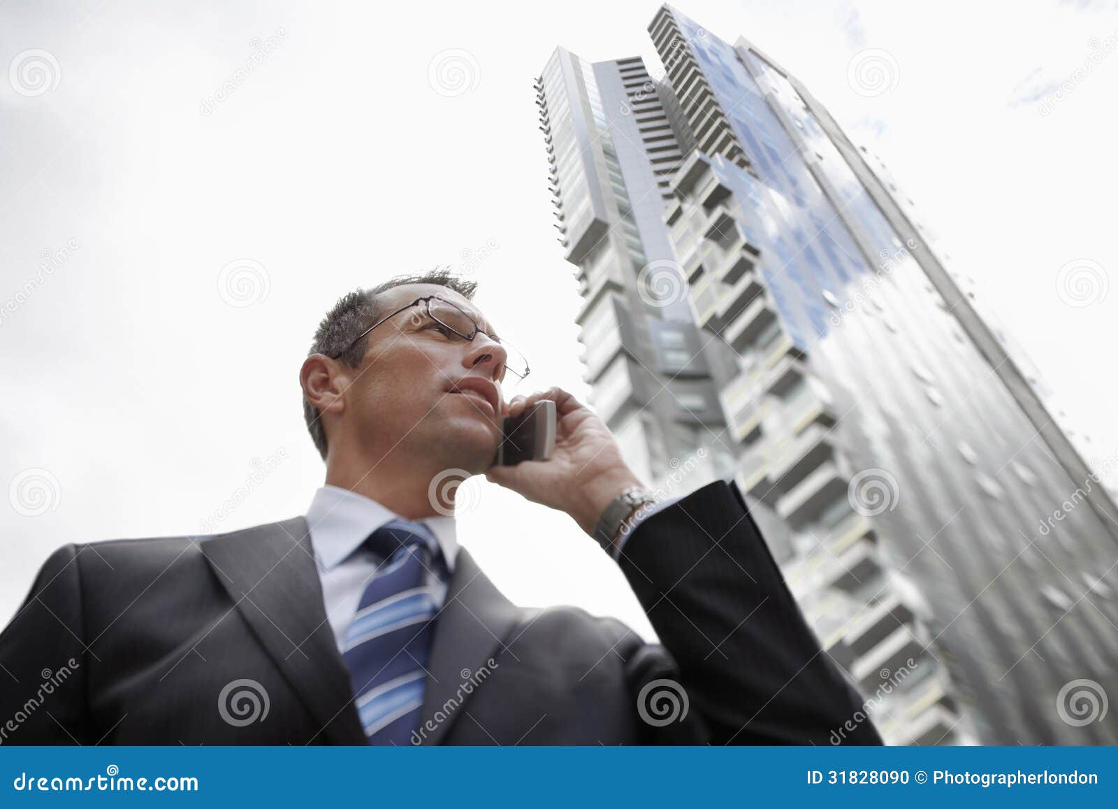 Businessman Using Mobile Phone Against Tall Building Stock Photo ...