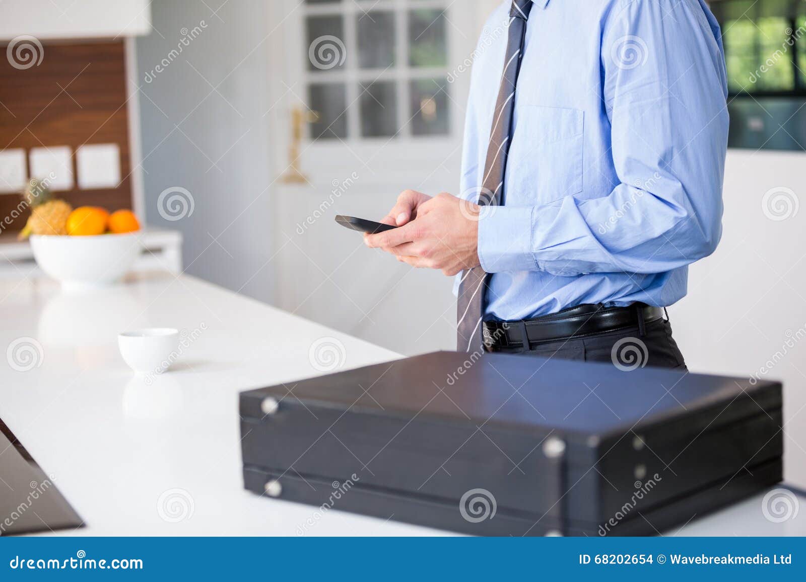Businessman Using Mobile Phone while Standing by Table Stock Photo ...