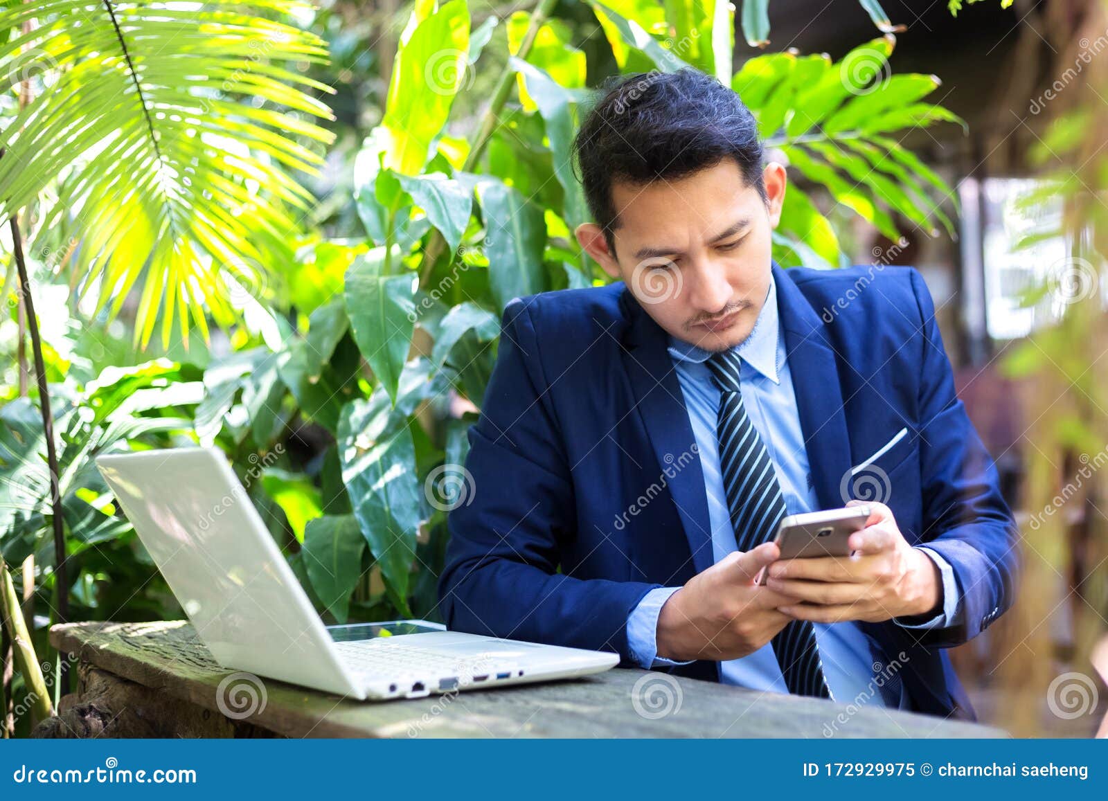 Businessman Using Mobile Smart Phone and Working on Laptop Computer ...
