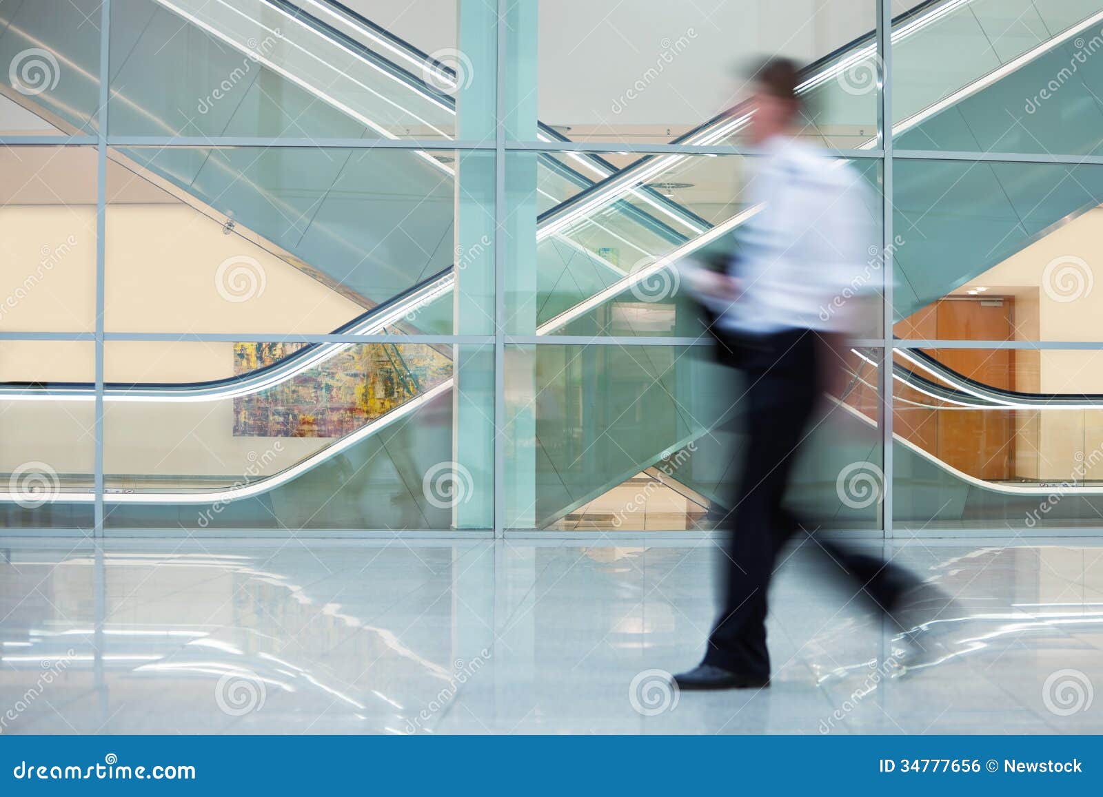 Businessman Walking Quickly Down Hall in Office Building Stock Photo ...