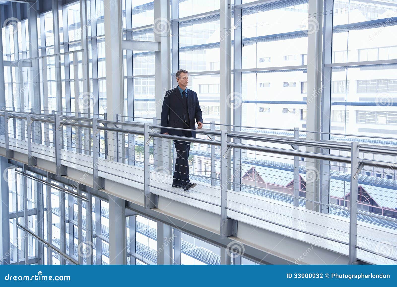 Businessman Walking by Railing in Modern Office Stock Photo - Image of ...