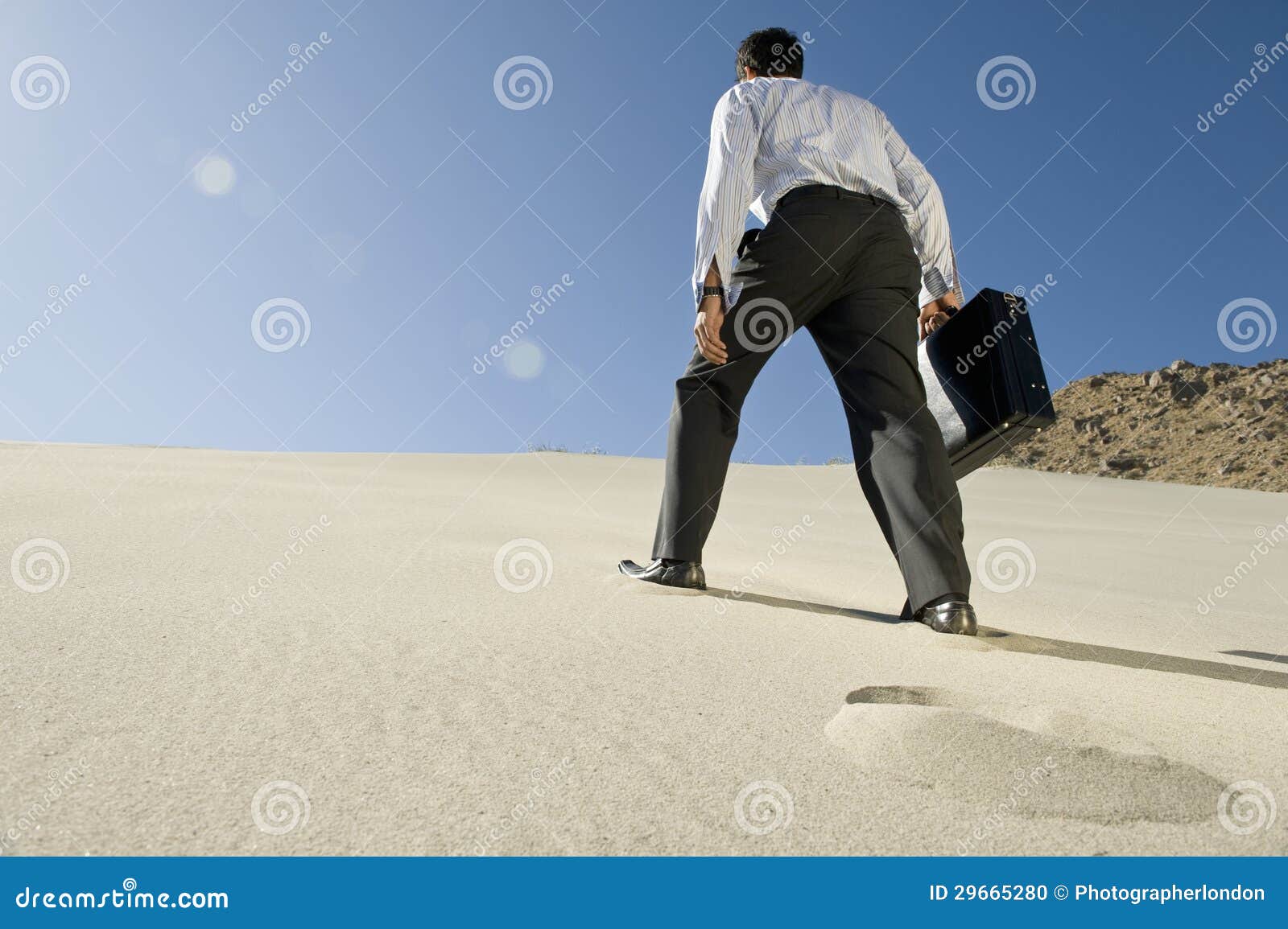 Businessman Walking Uphill in Desert Stock Photo - Image of ...