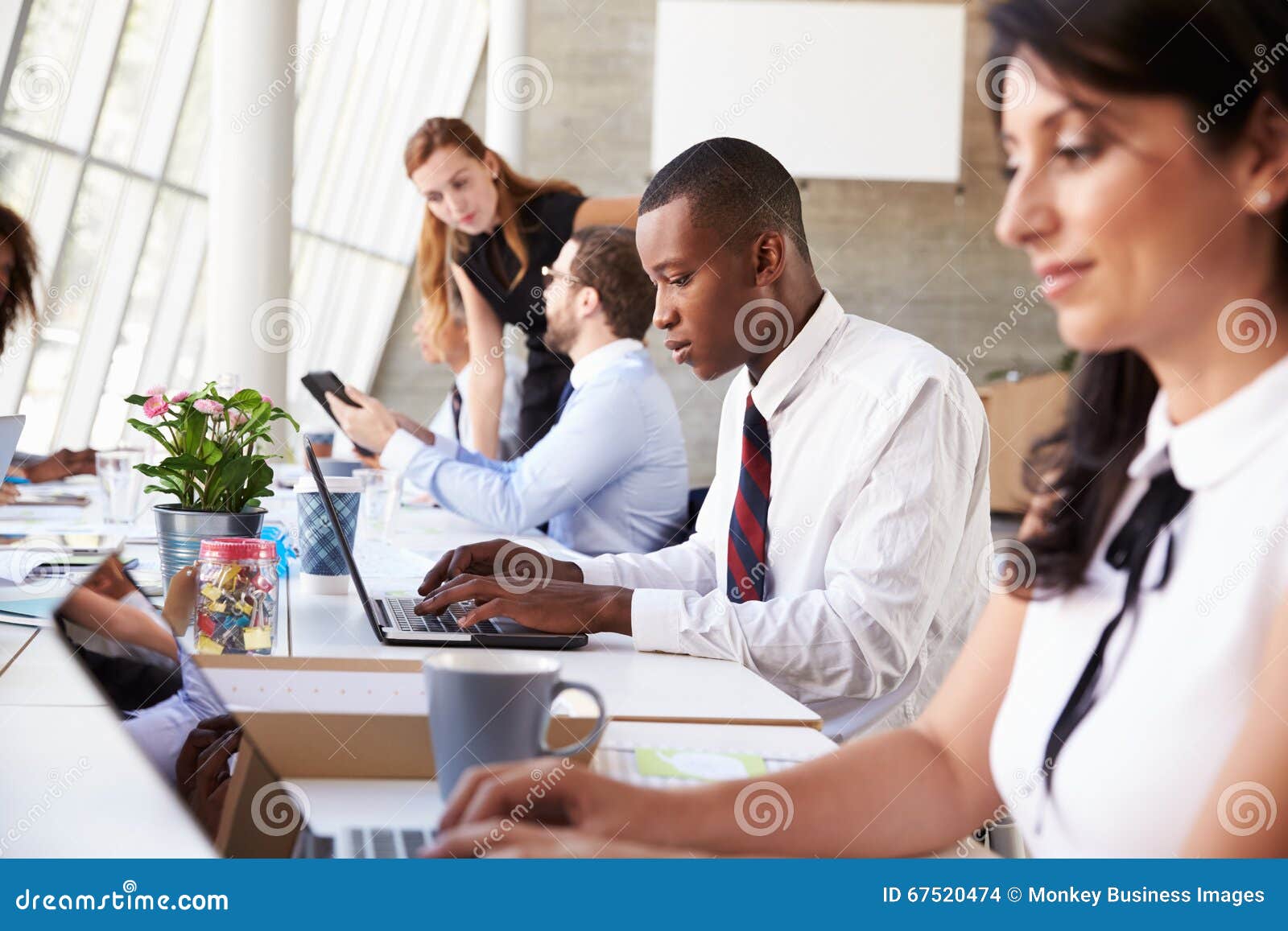 Businessman Working on Laptop in Busy Office Stock Photo - Image of ...