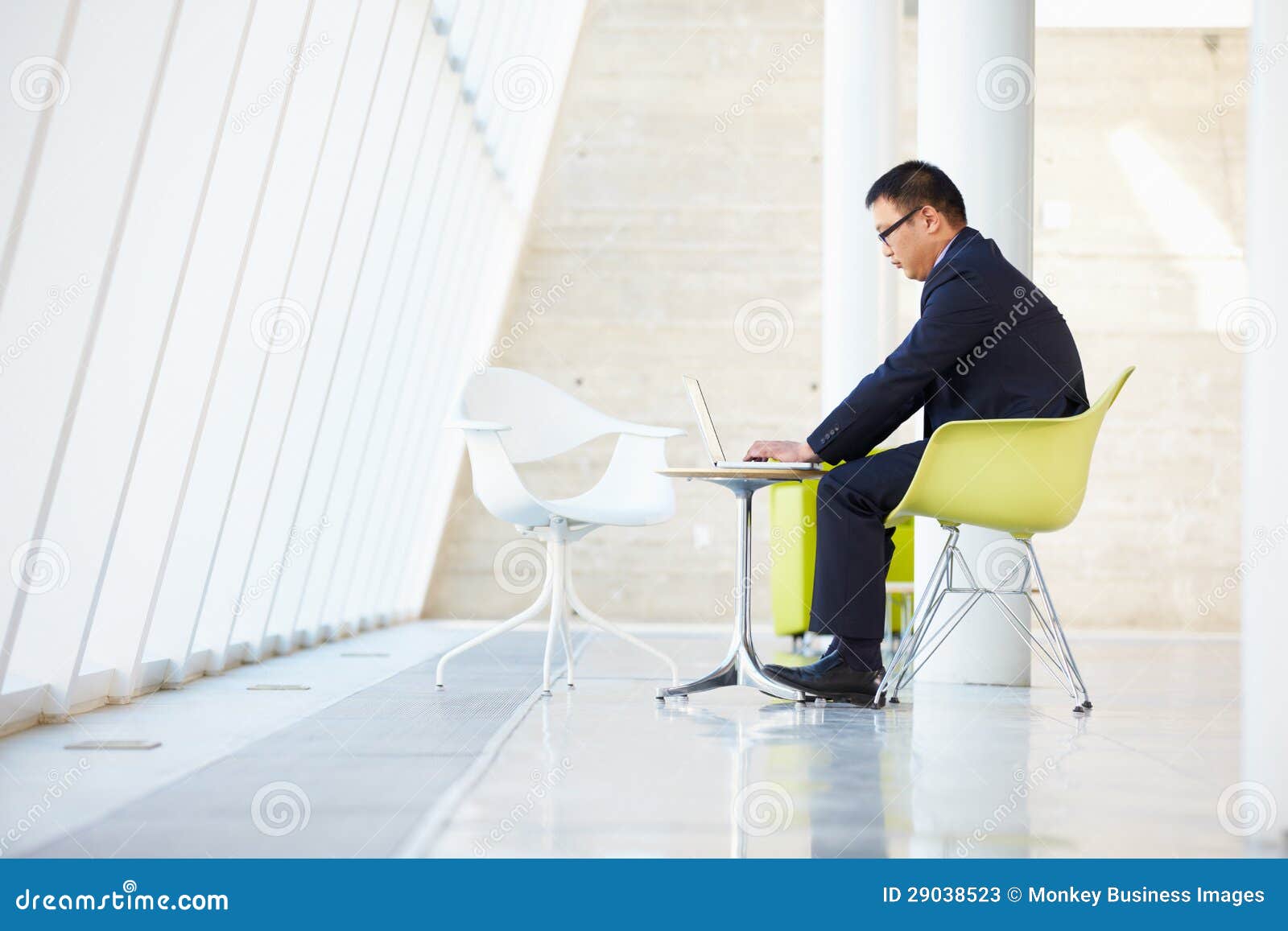 Businessman Working on Laptop at Table in Modern Office Stock Image ...