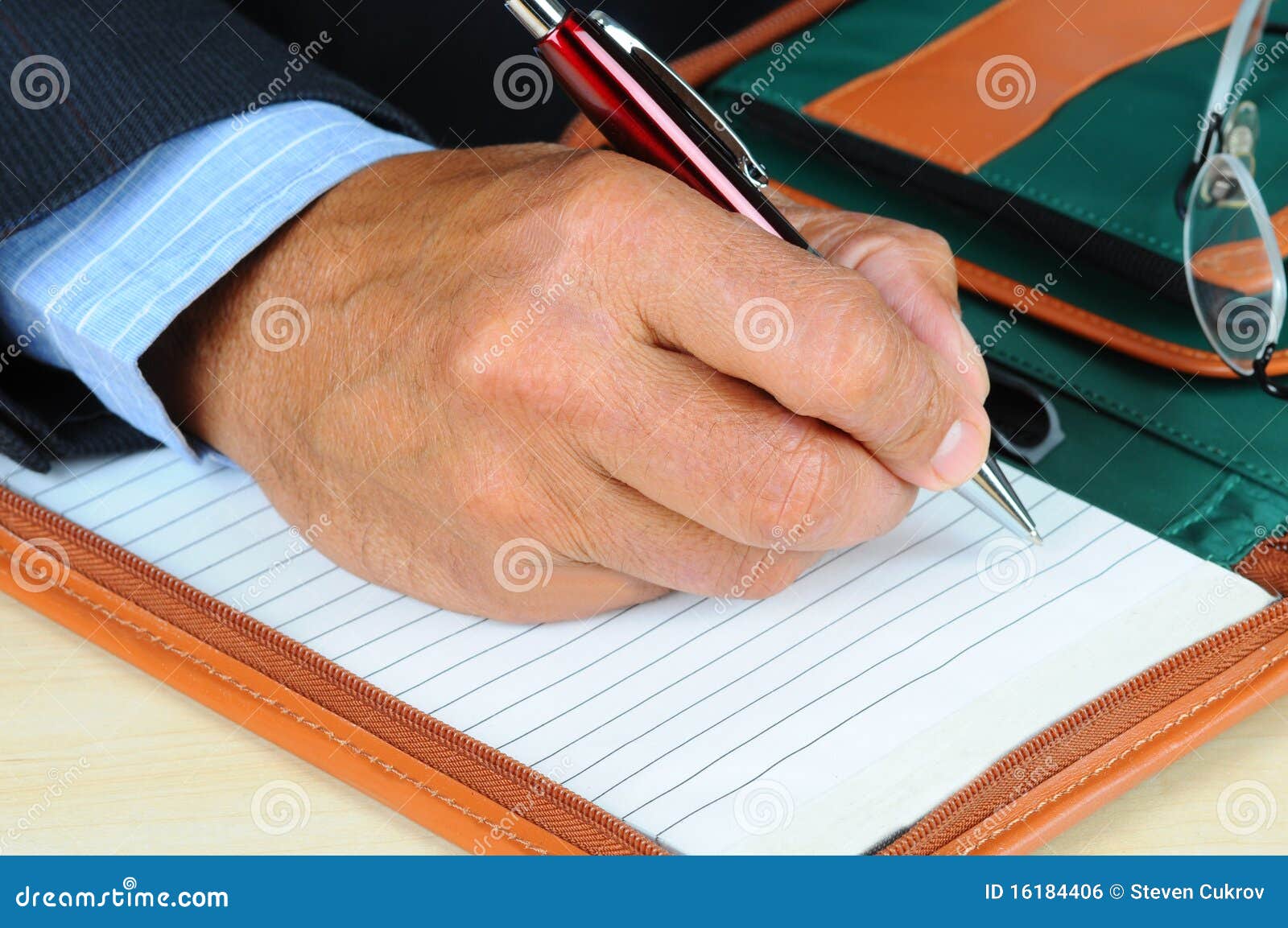 Businessman Writing in Note Pad Stock Photo - Image of interior, shirt ...