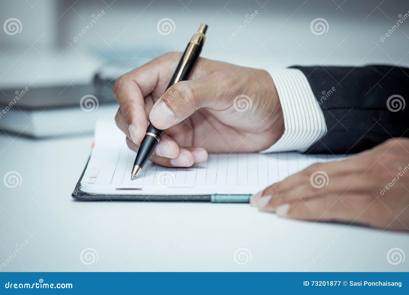 Businessman Writing on Notebook with Pen in the Office Stock Image ...