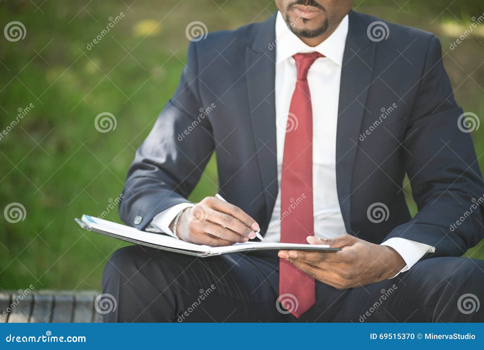 Businessman Writing Notes while Sitting on a Bench Stock Photo - Image ...