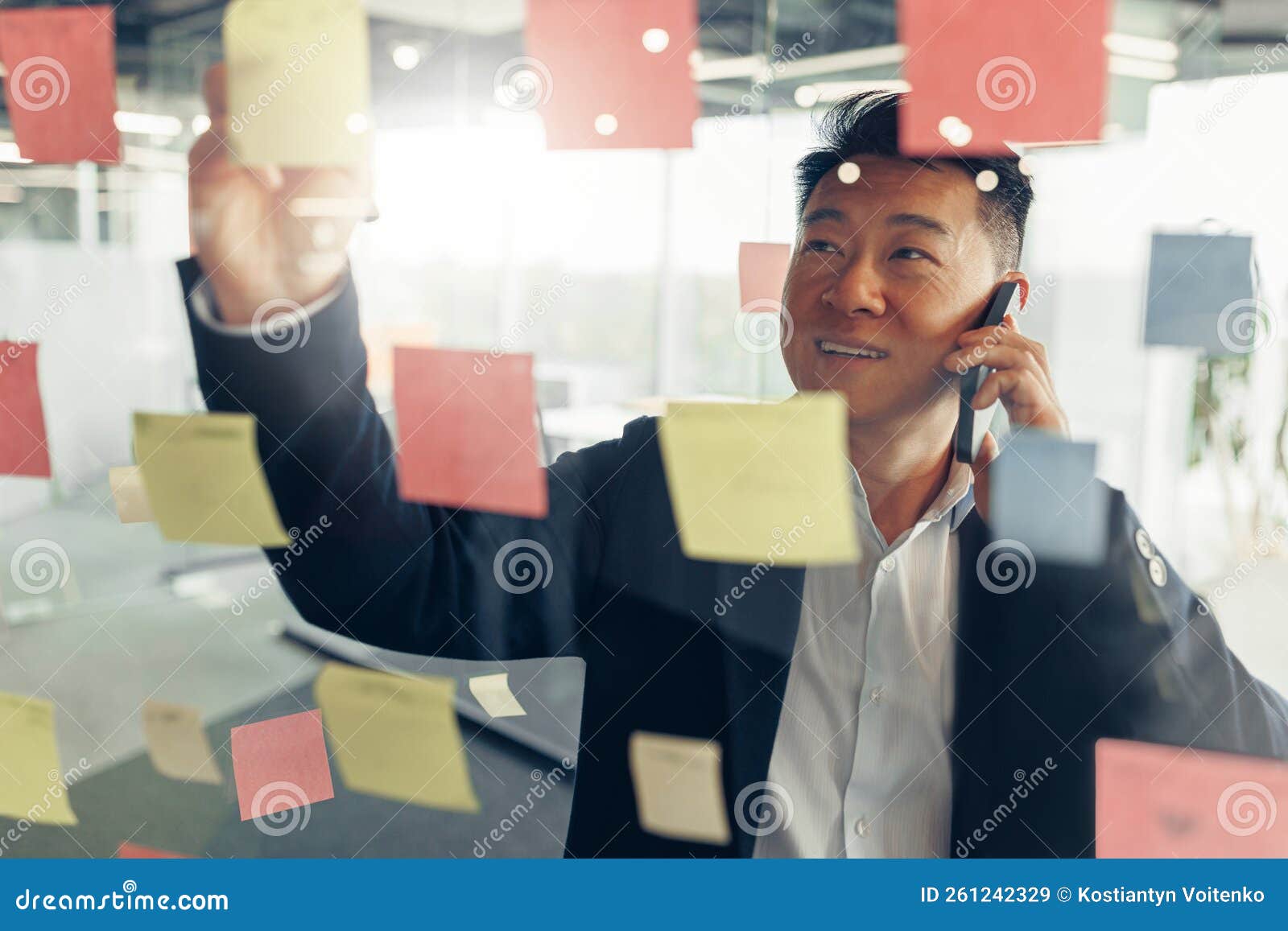 Businessman Writing on Sticky Notes on Glass Wall while Working in ...