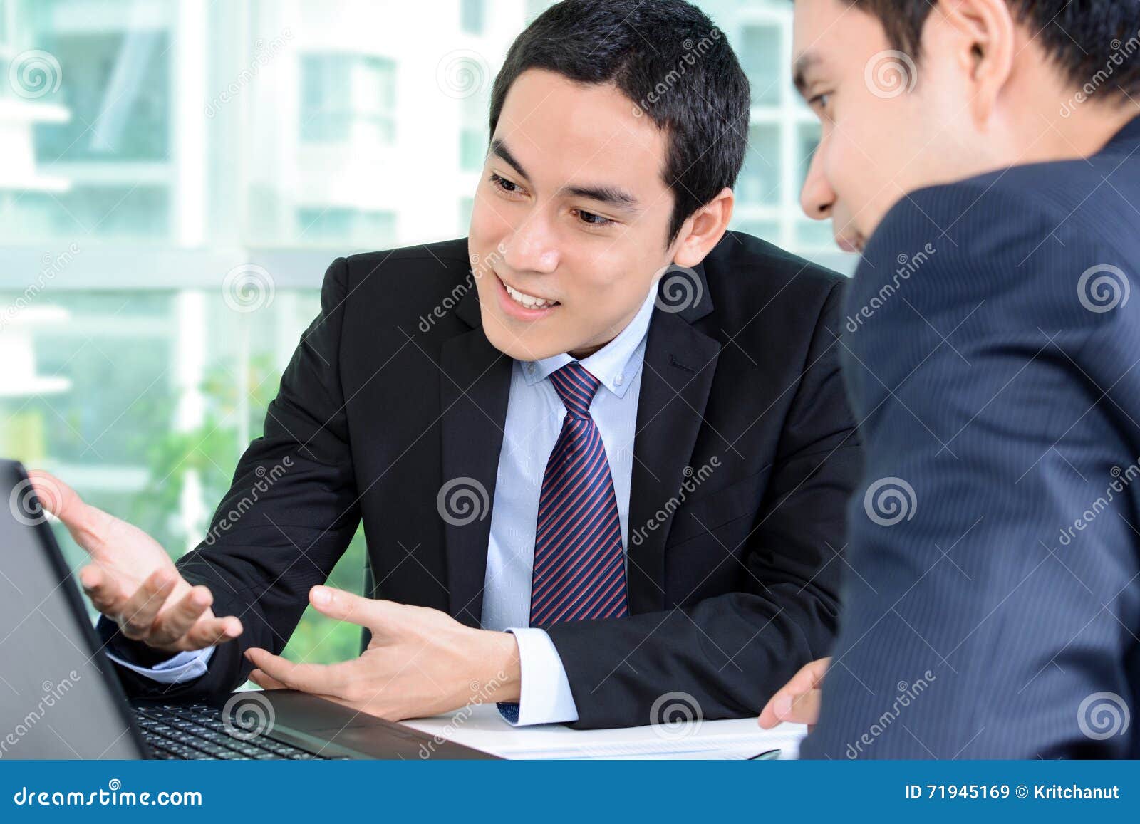 Businessmen Discussing Work while Looking at Laptop Computer Stock ...