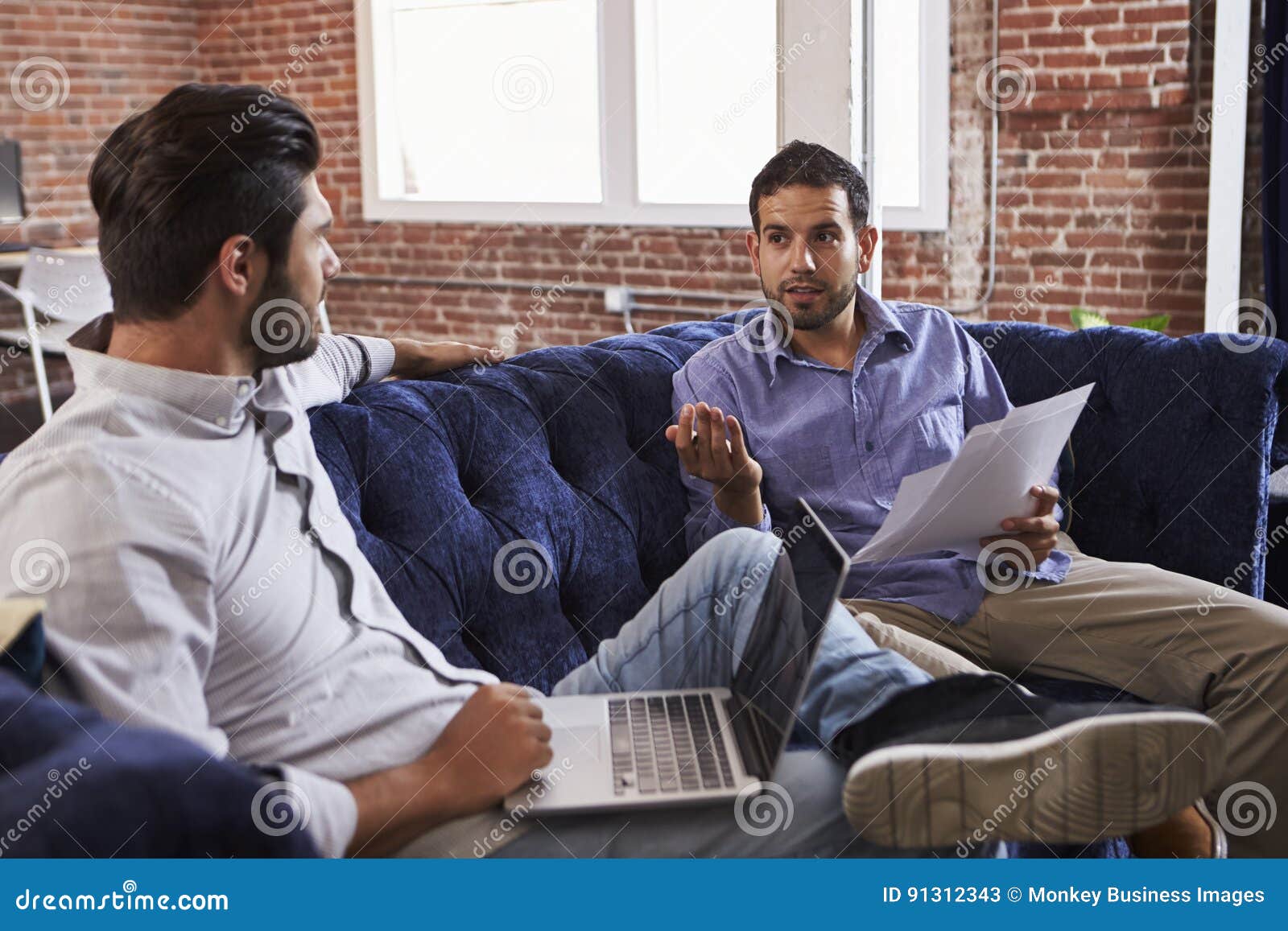 Businessmen Having Informal Meeting on Sofa in Modern Office Stock ...