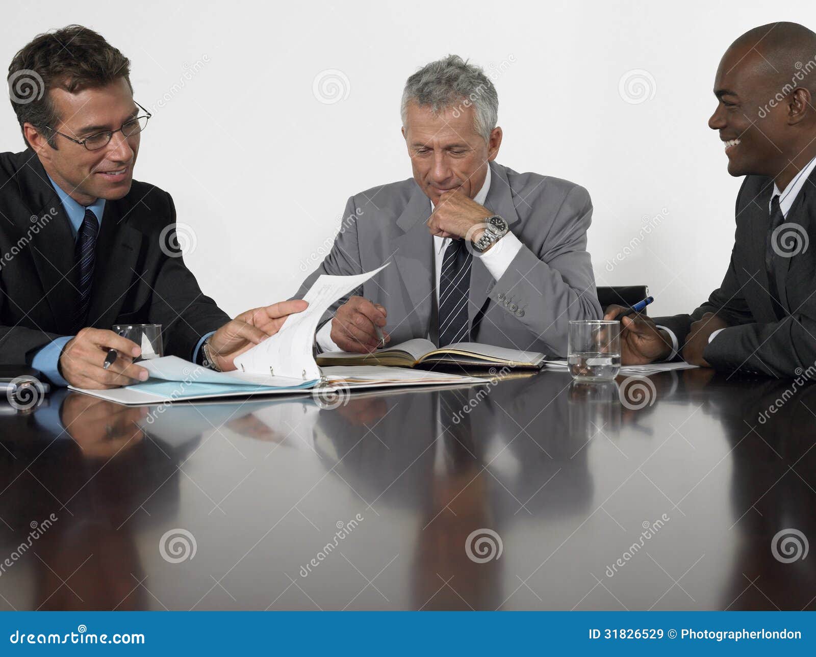 Businessmen Reading Documents in Conference Room Stock Image - Image of ...