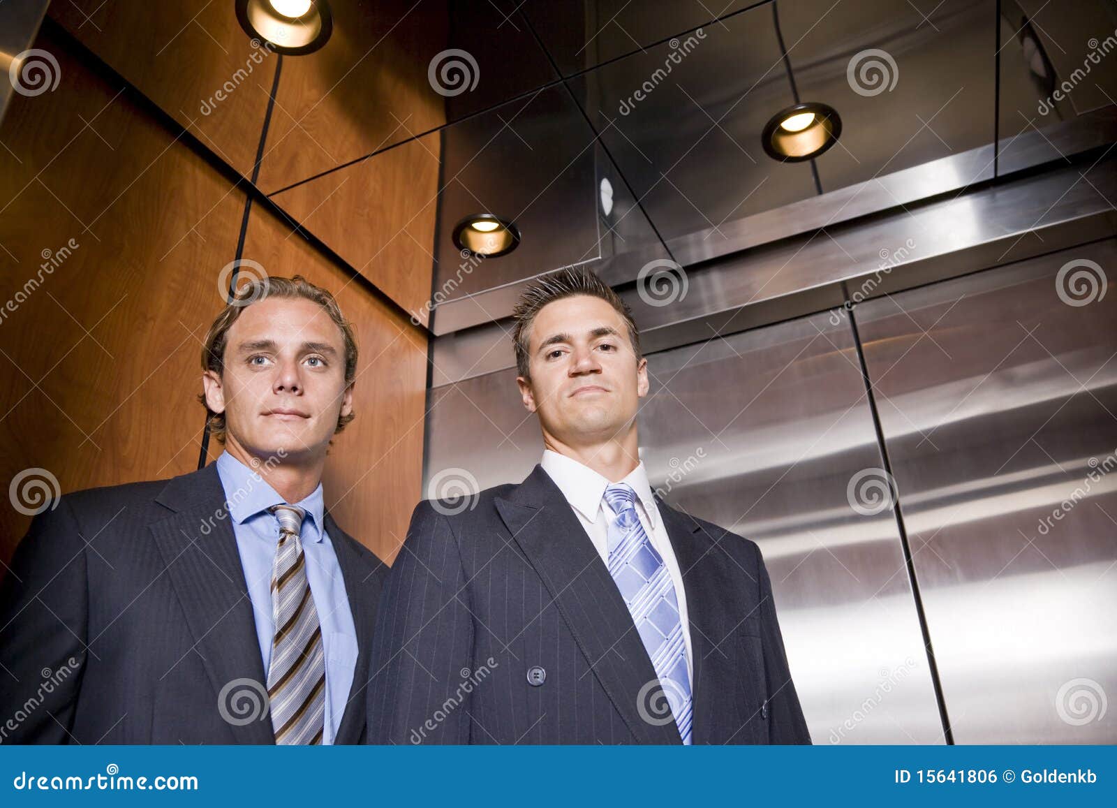 Businessmen Riding in Elevator Stock Photo - Image of years, standing ...