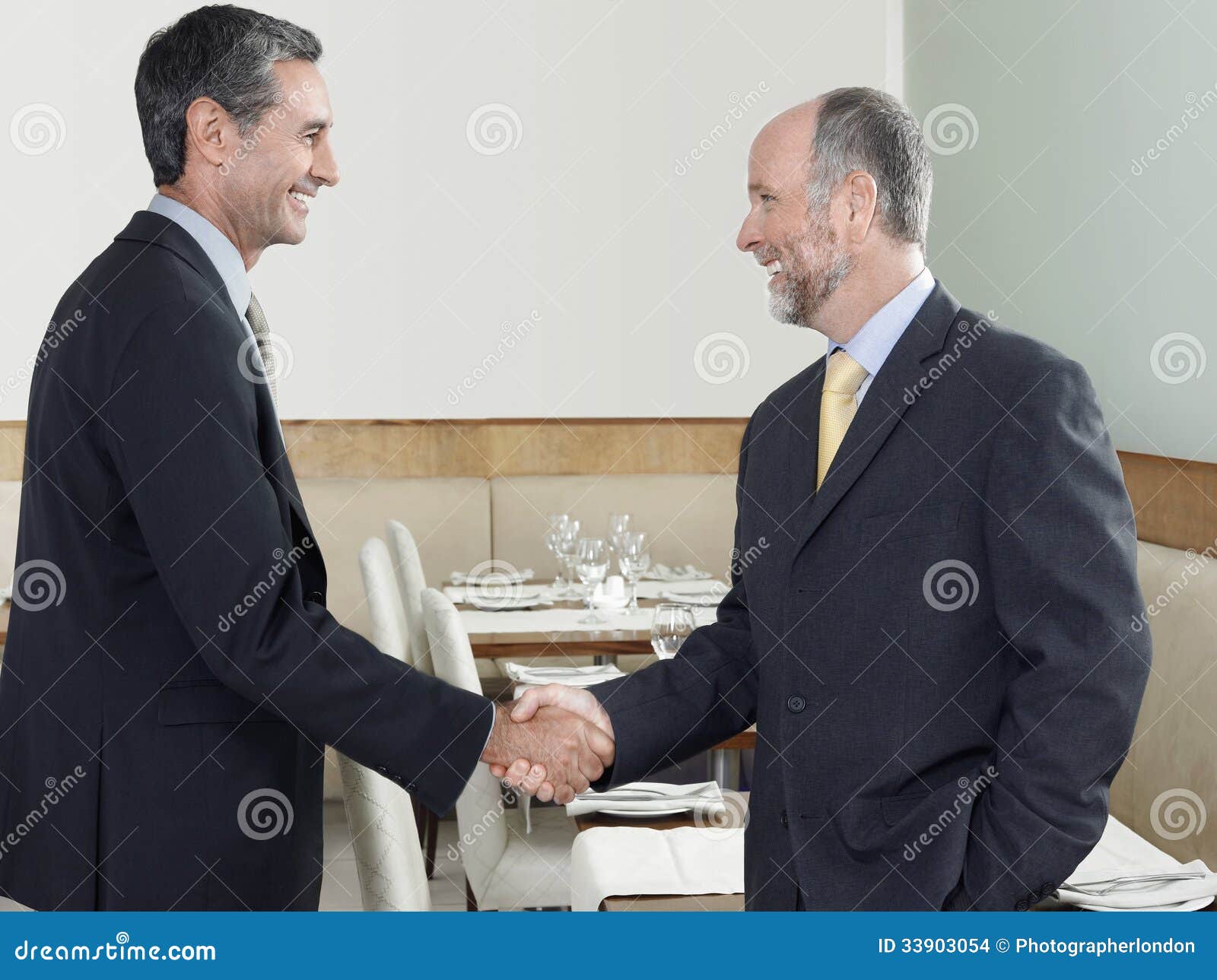 Businessmen Shaking Hands in Restaurant Stock Photo - Image of male ...
