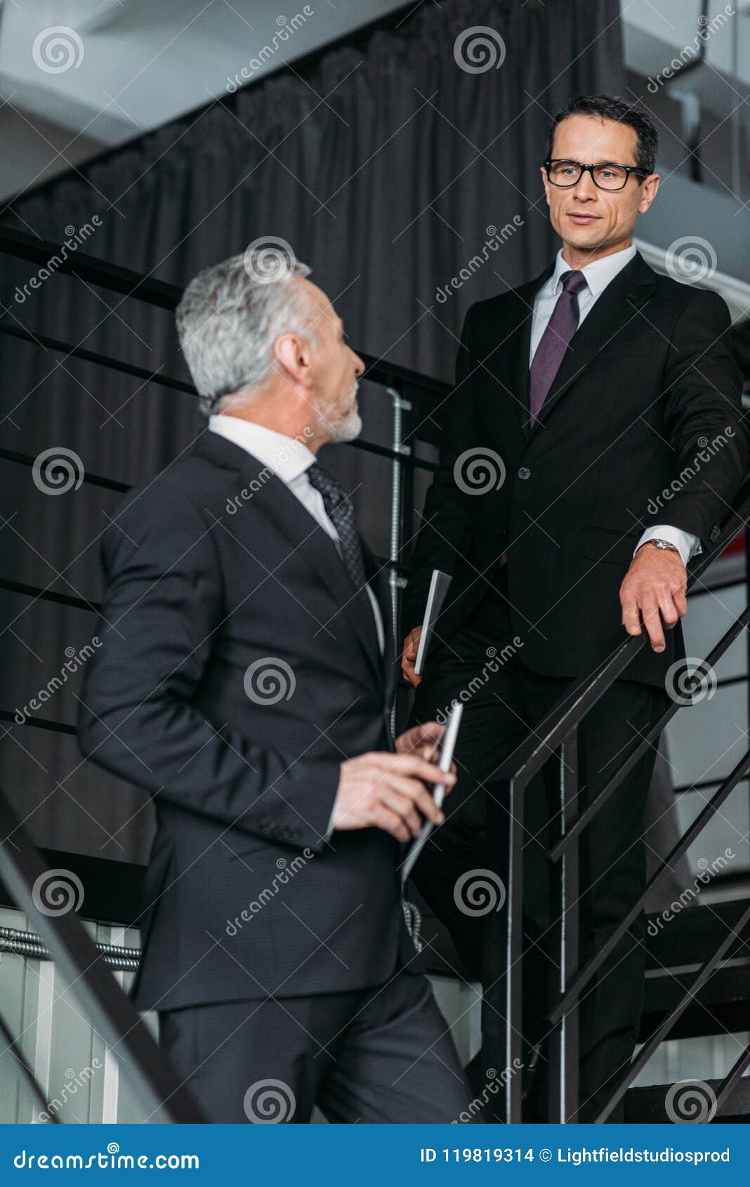 Businessmen in Suits Having Conversation while Going Down on Steps ...