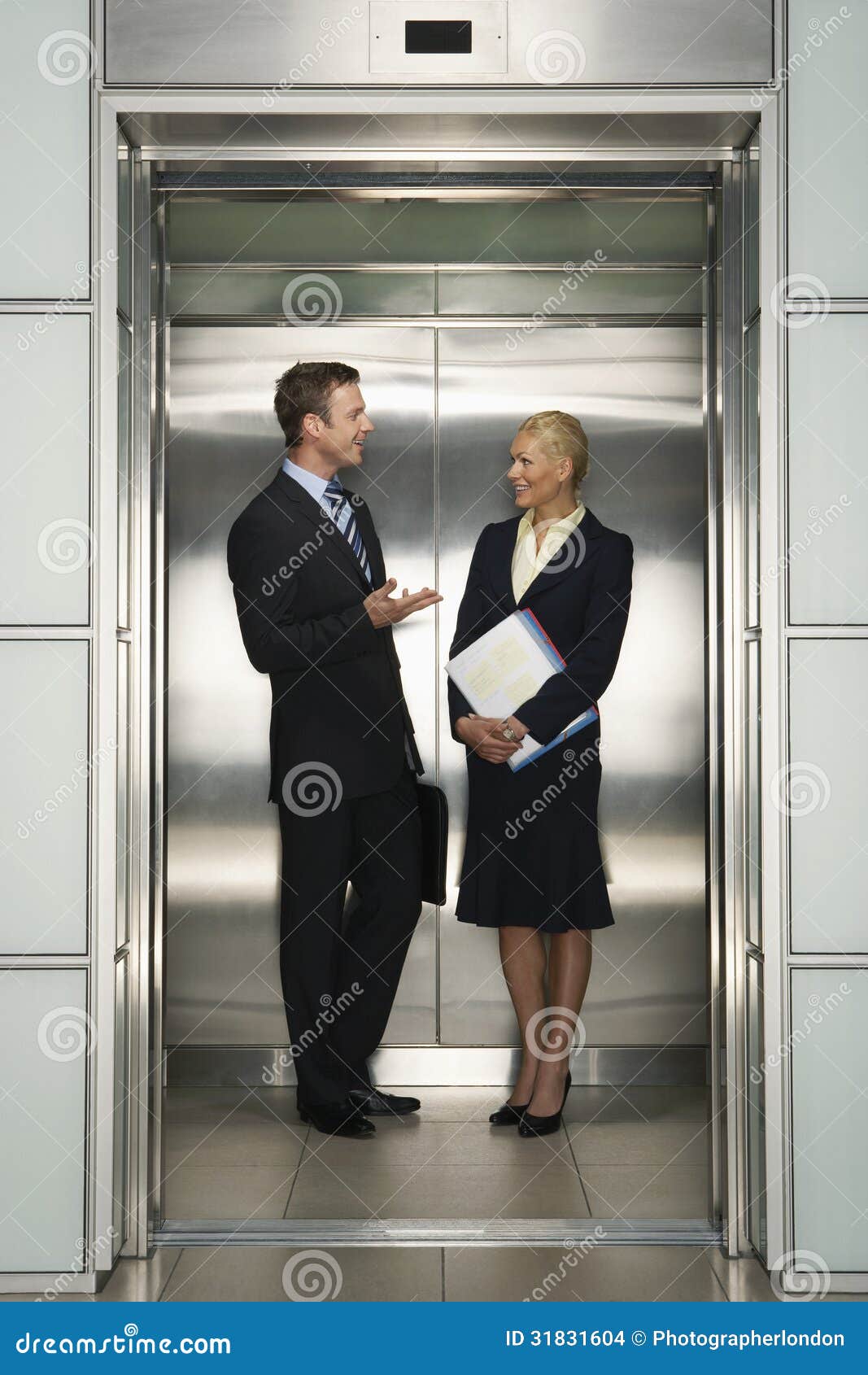 Businesspeople Communicating in Elevator Stock Photo - Image of ...