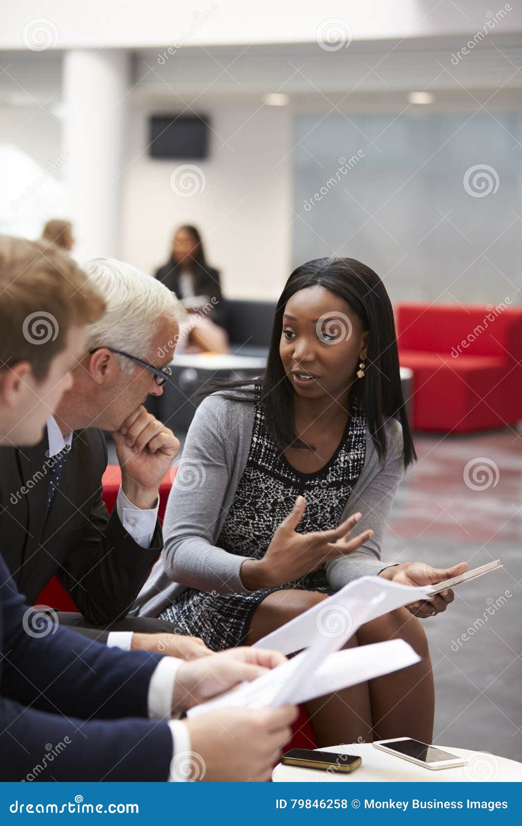 Businesspeople Discuss Document in Lobby of Modern Office Stock Photo ...