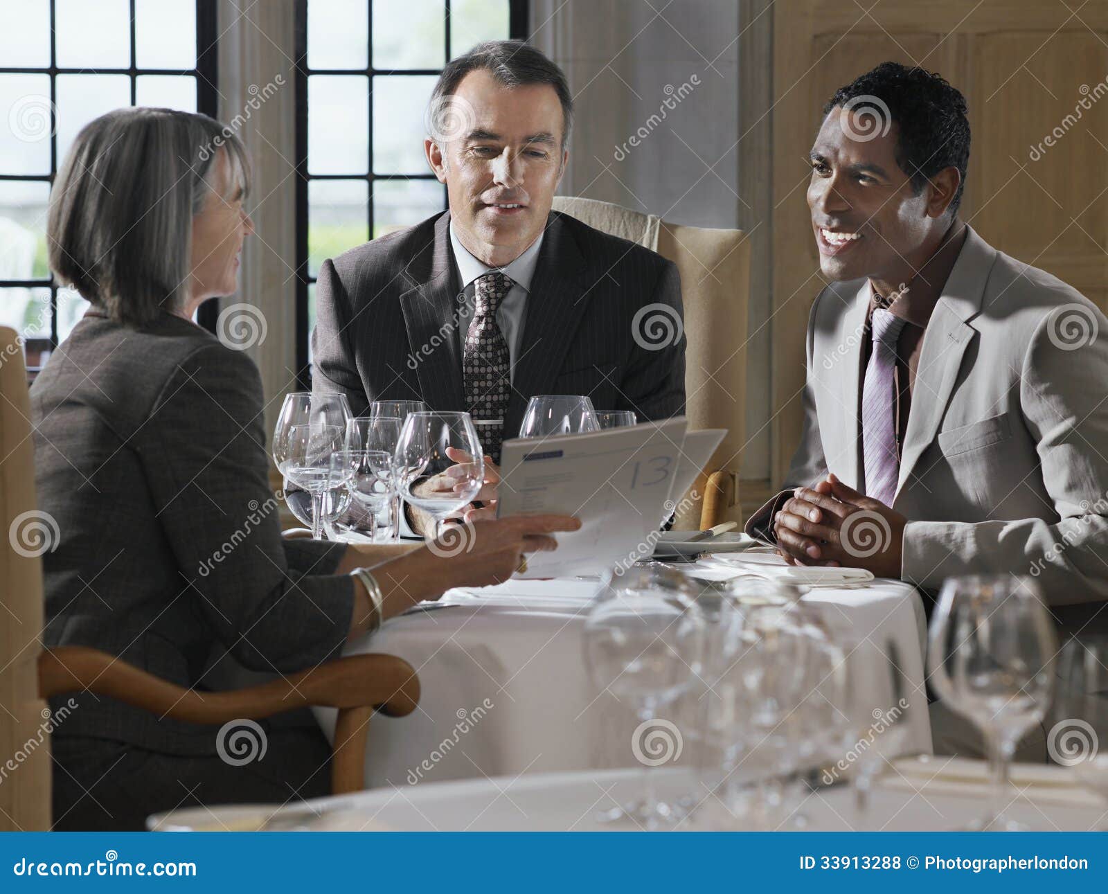 Businesspeople Discussing Documents at Restaurant Table Stock Photo ...