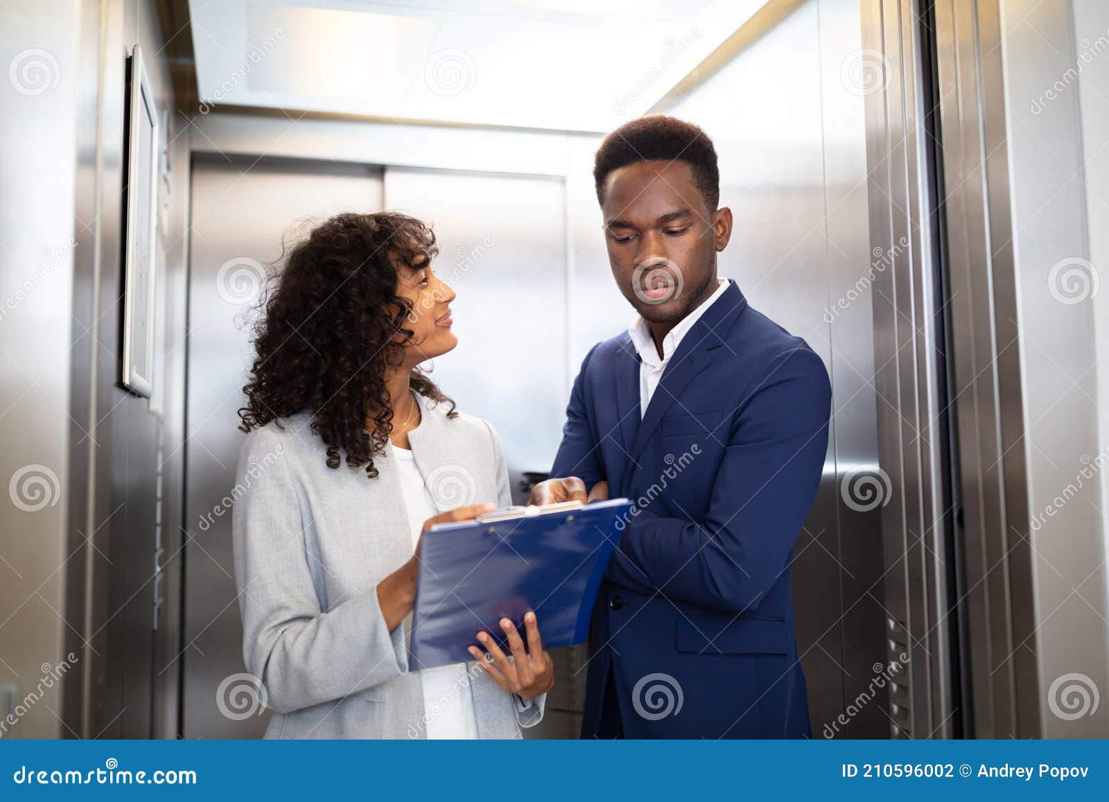Businesspeople Discussing Standing Inside Elevator Stock Photo - Image ...