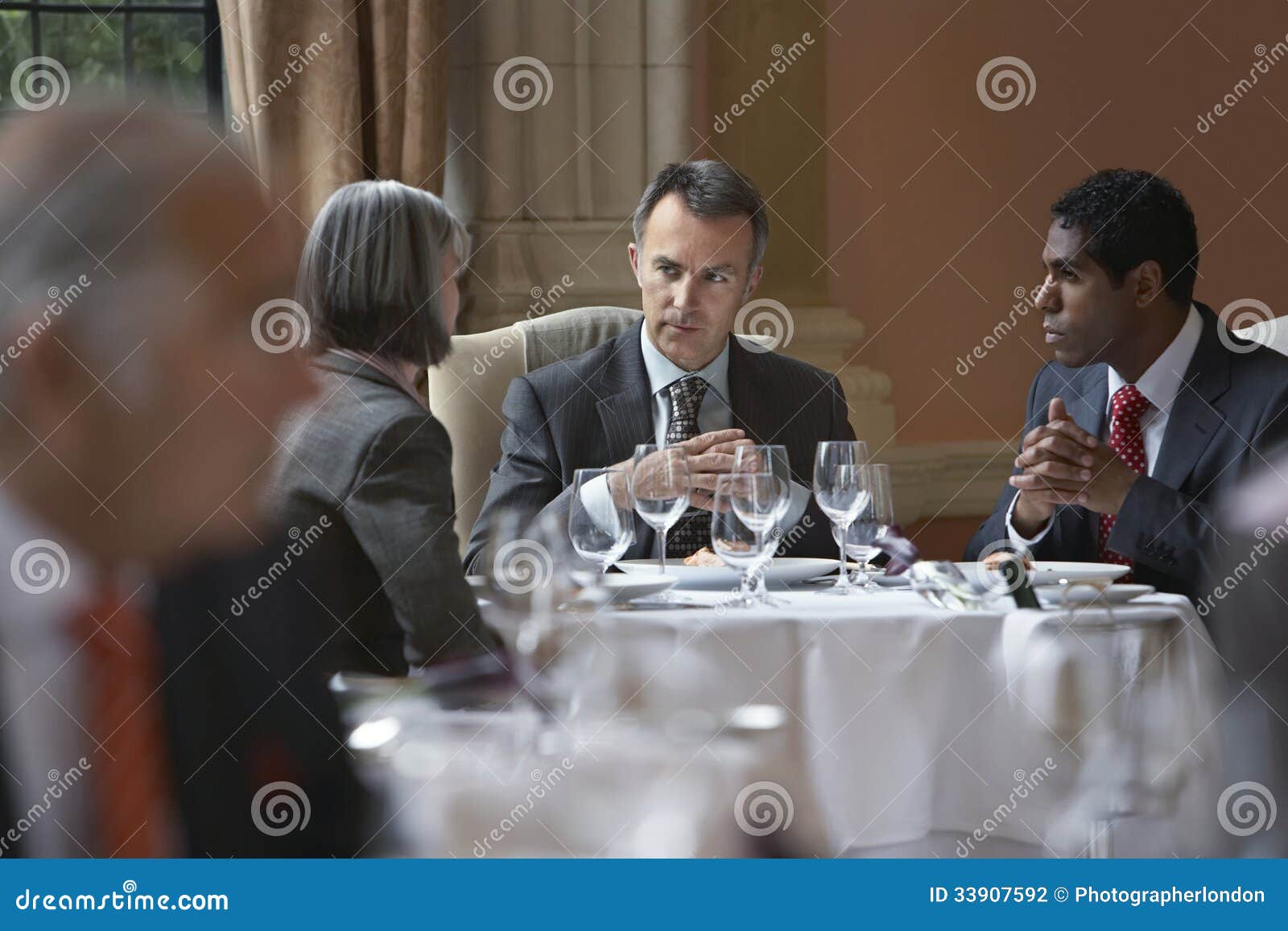 Businesspeople Talking at Restaurant Table Stock Photo - Image of ...