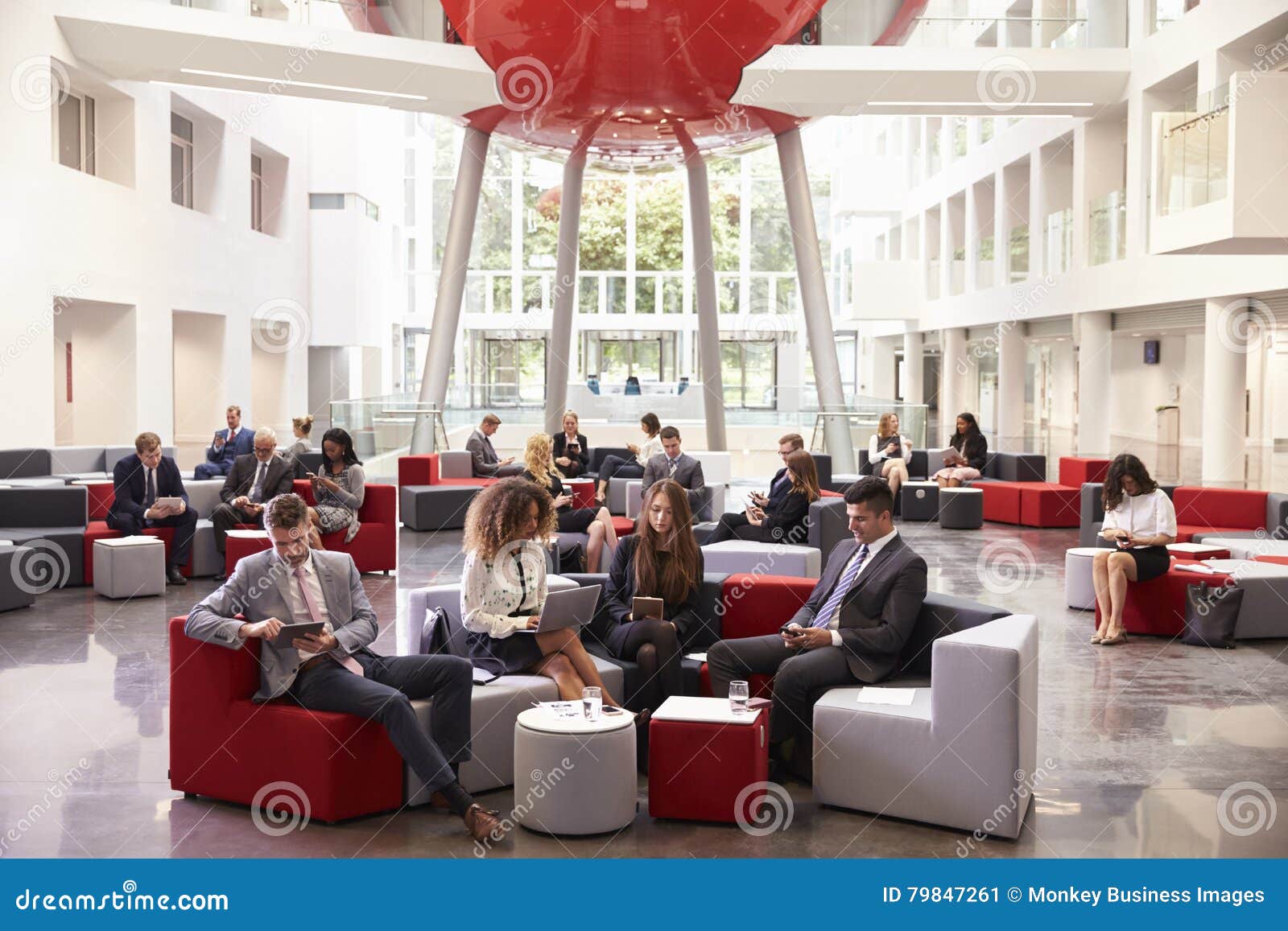 Businesspeople Using Digital Devices in Busy Office Lobby Stock Image ...