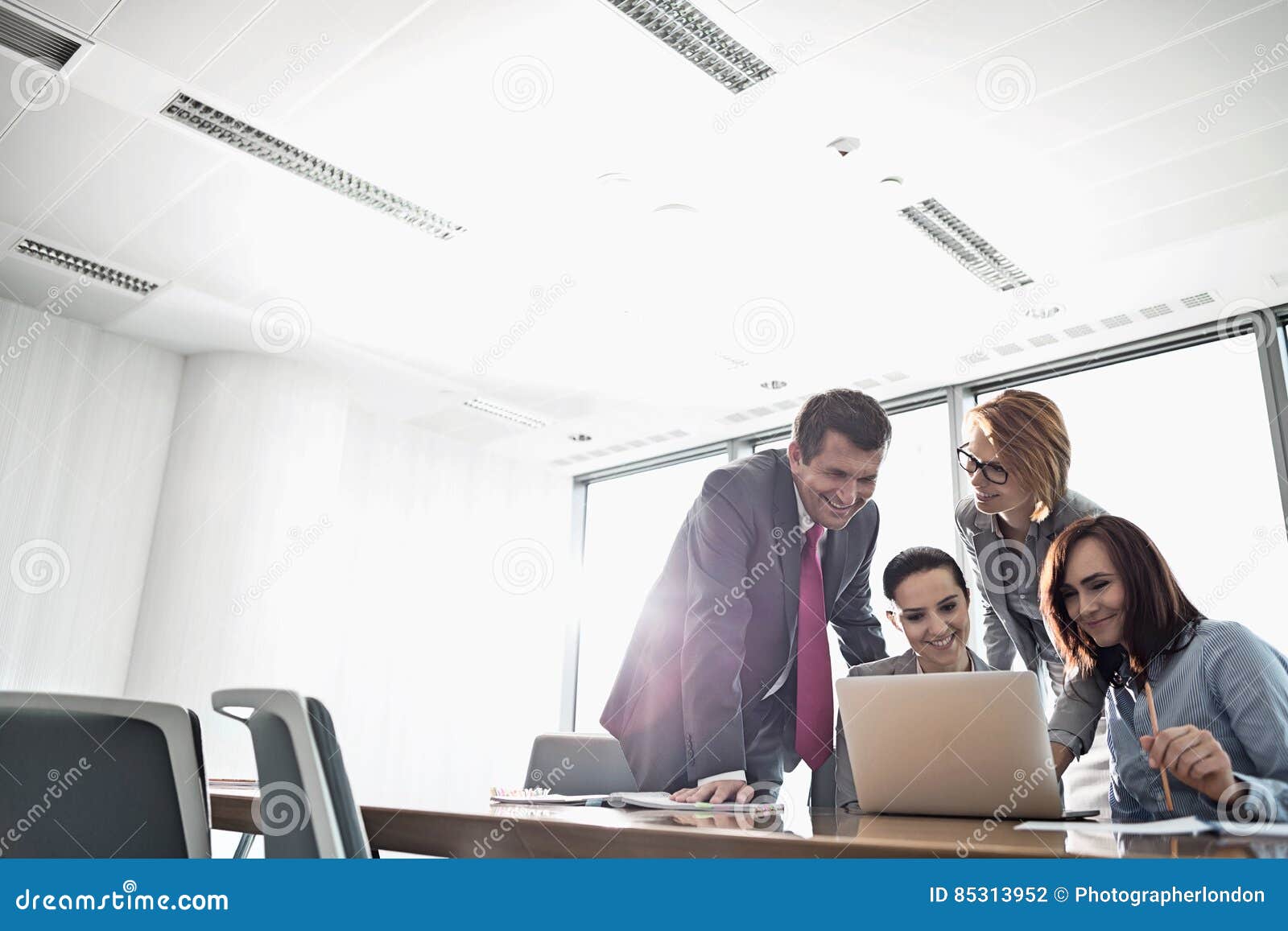 Businesspeople Using Laptop at Conference Table Stock Photo - Image of ...