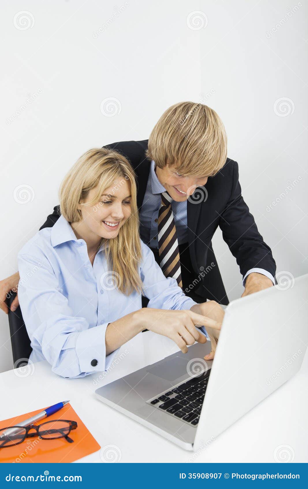 Businesspeople Using Laptop at Desk in Office Stock Image - Image of ...