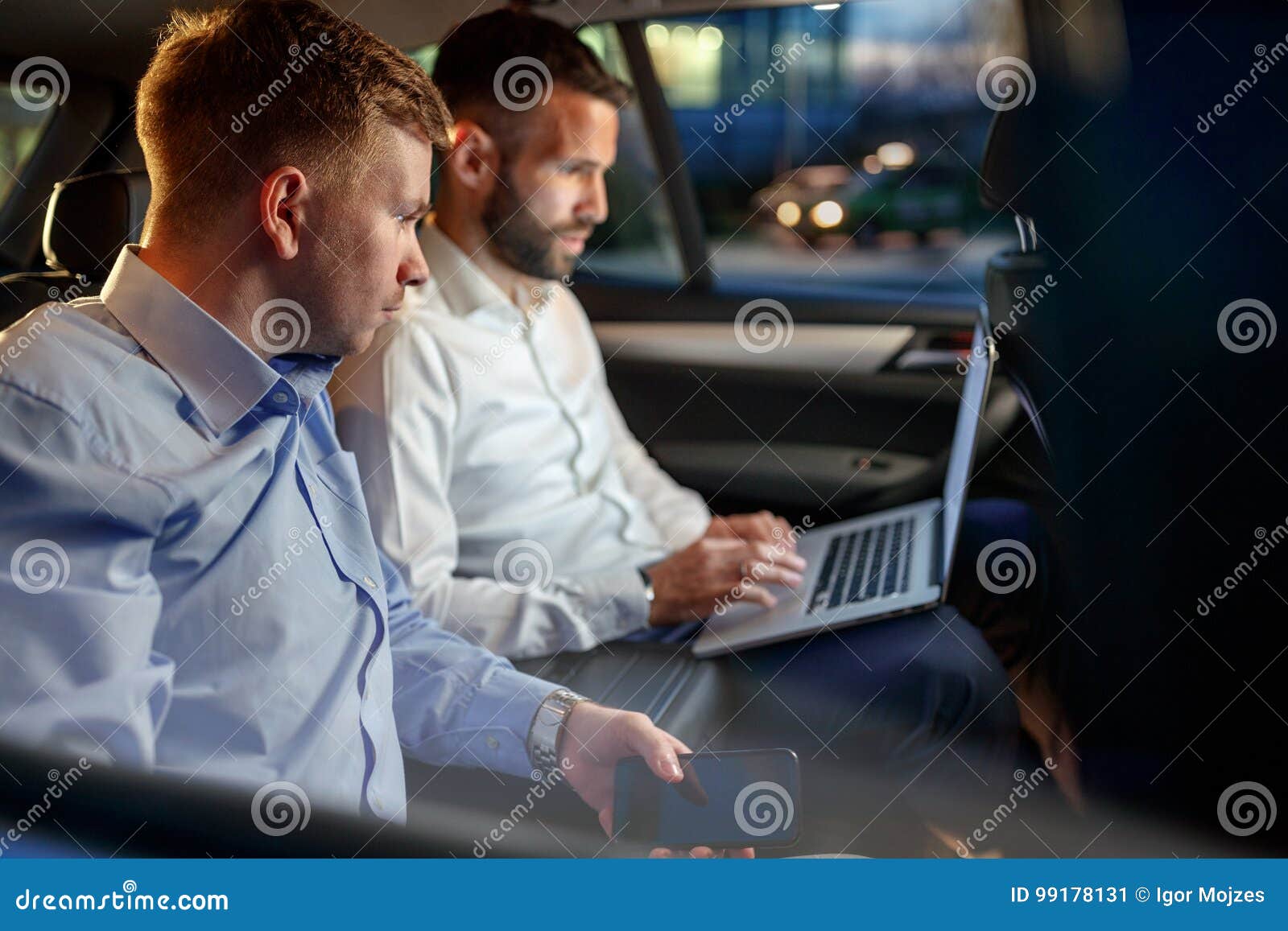 Businesspeople Work on Late Night in Back Seat of Car Stock Image ...