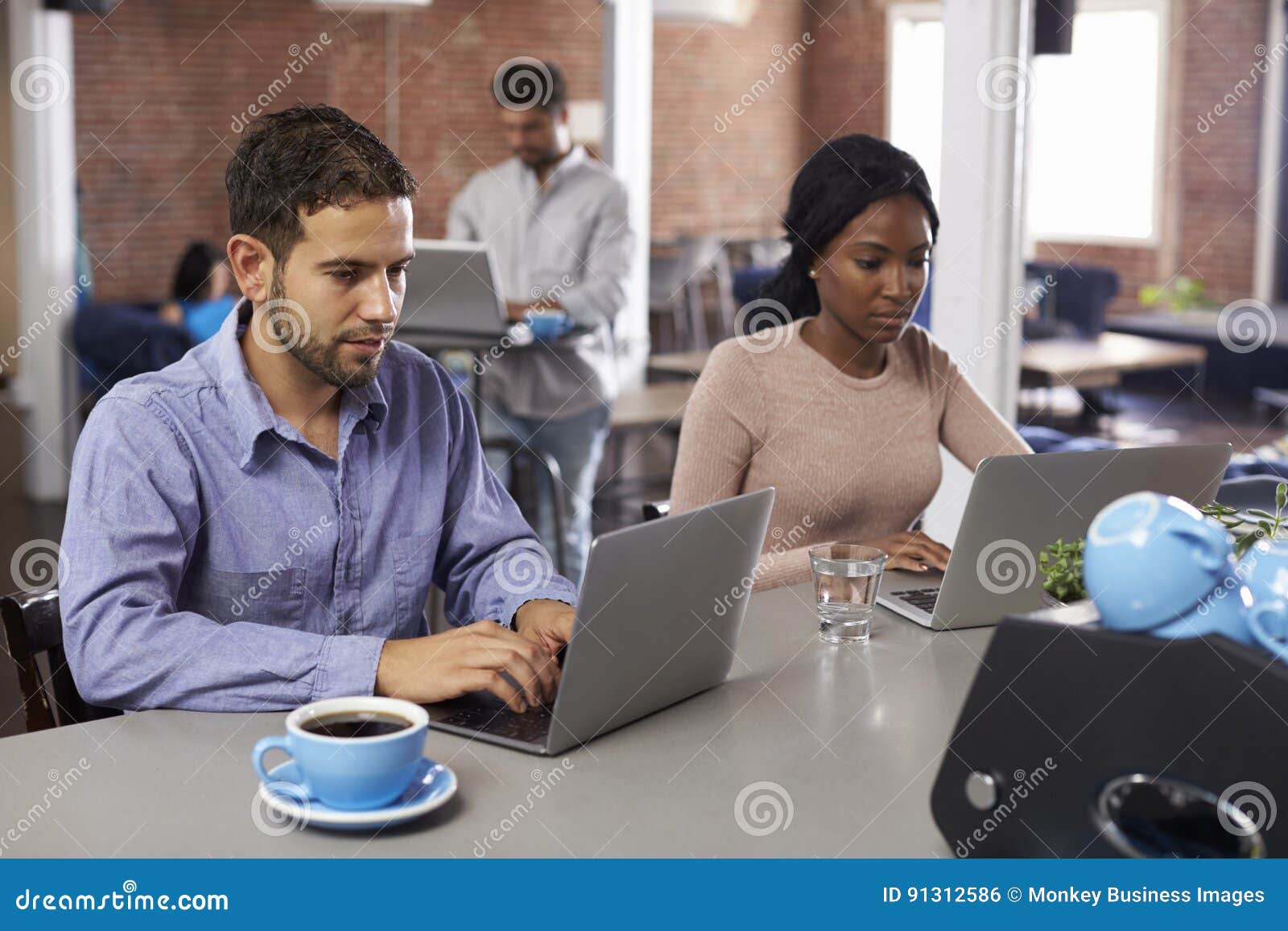 Businesspeople Working on Laptops in Office Coffee Bar Stock Photo ...