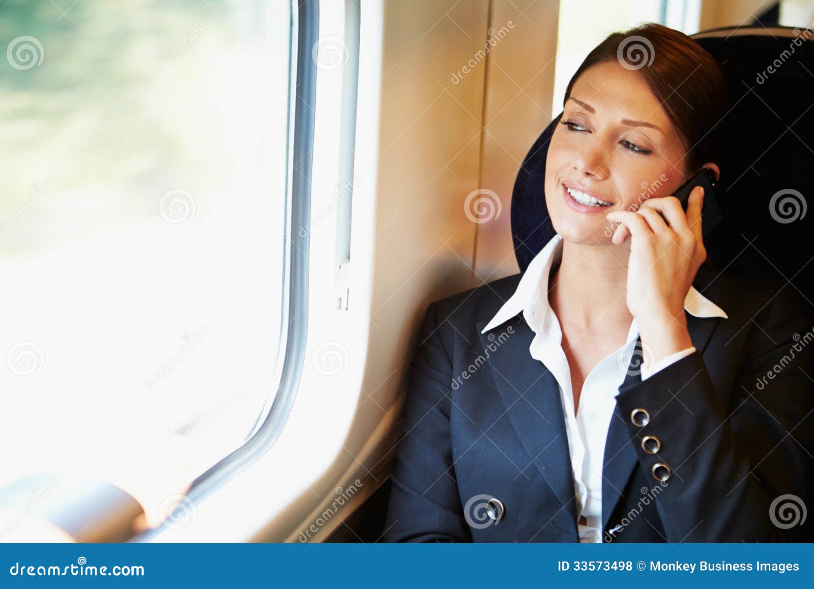 Businesswoman Commuting To Work on Train Using Mobile Phone Stock Photo ...