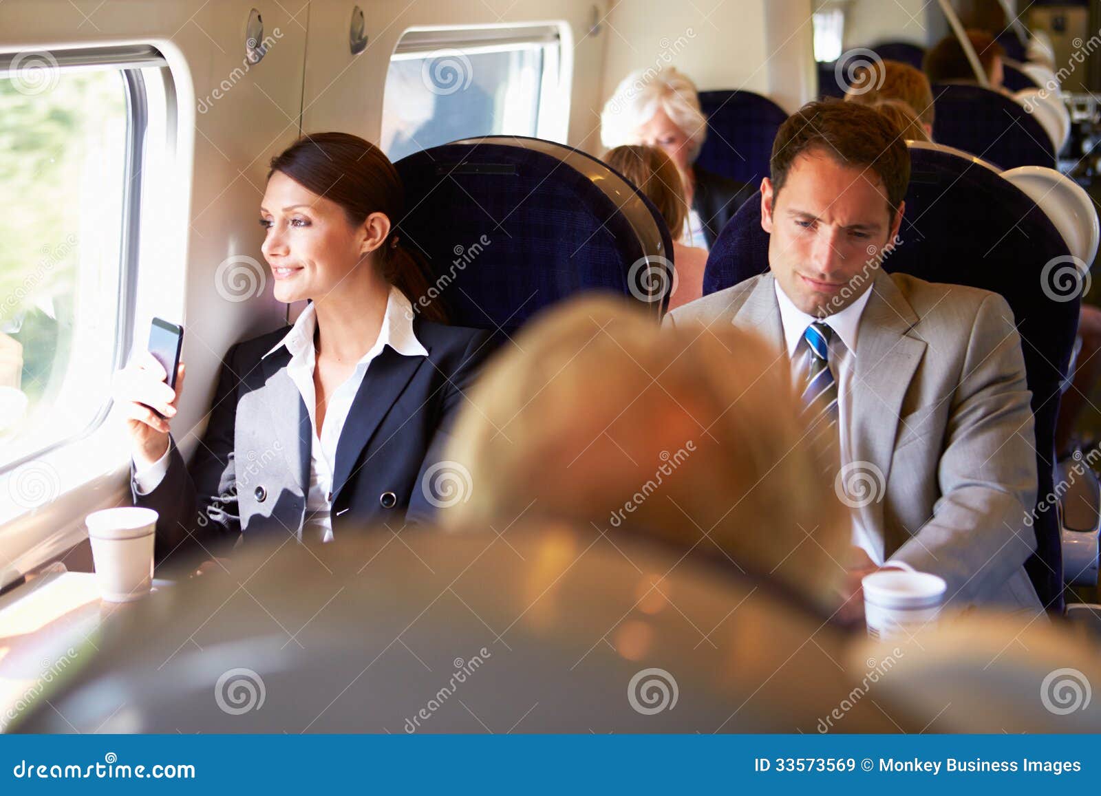 Businesswoman Commuting To Work on Train Using Mobile Phone Stock Image ...