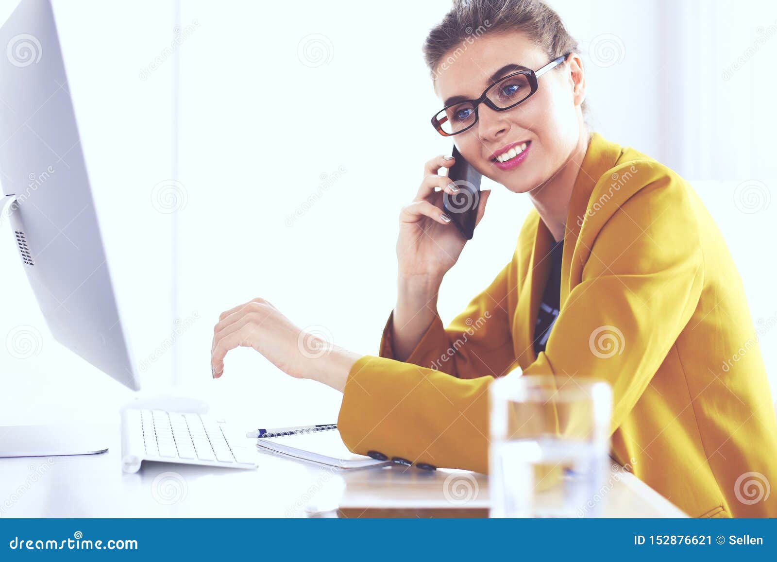 Businesswoman Concentrating on Work, Using Computer and Cellphone in ...