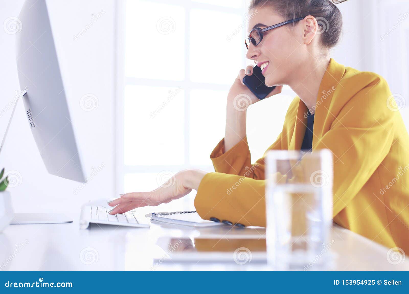 Businesswoman Concentrating on Work, Using Computer and Cellphone in ...