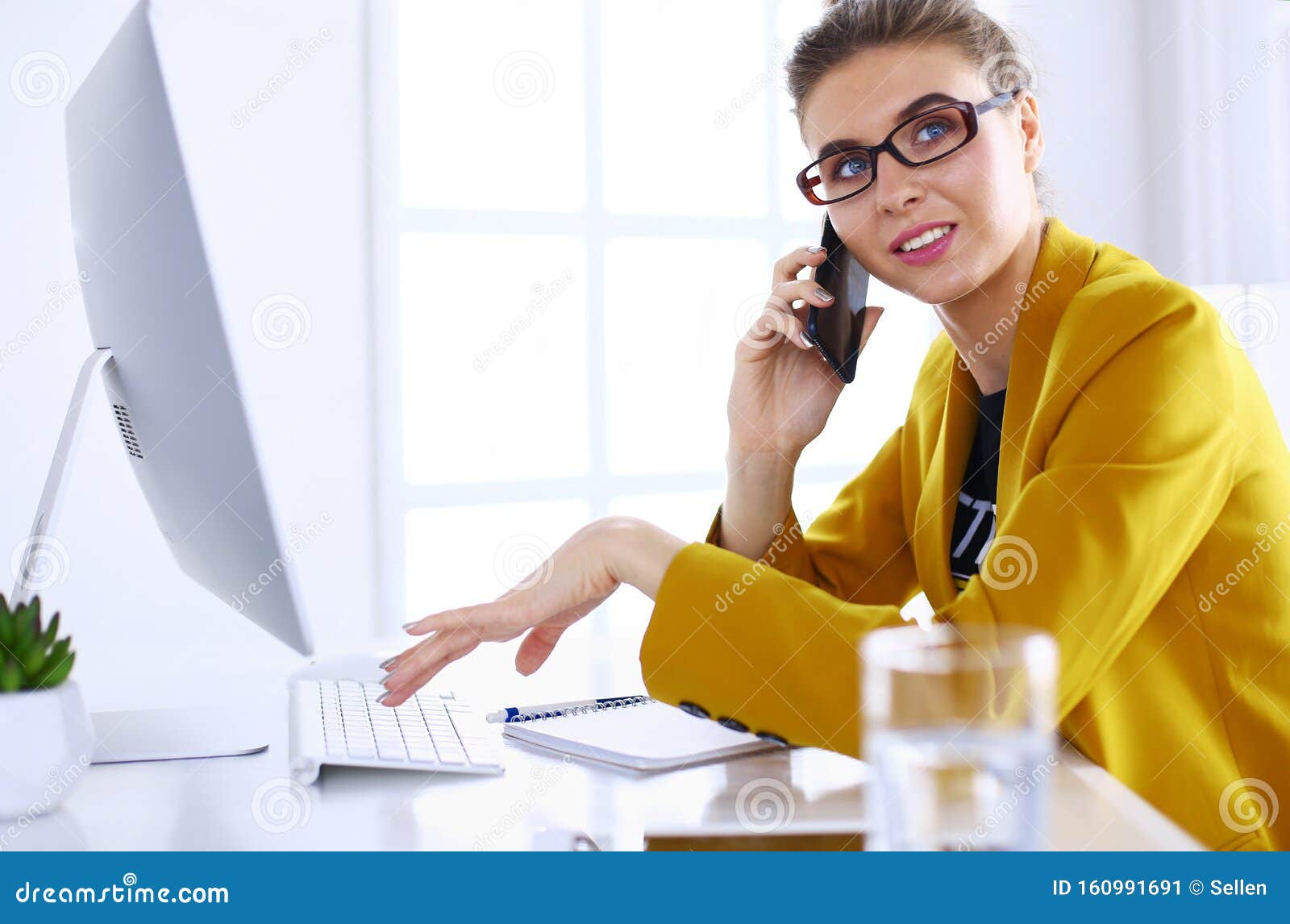 Businesswoman Concentrating on Work, Using Computer and Cellphone in ...