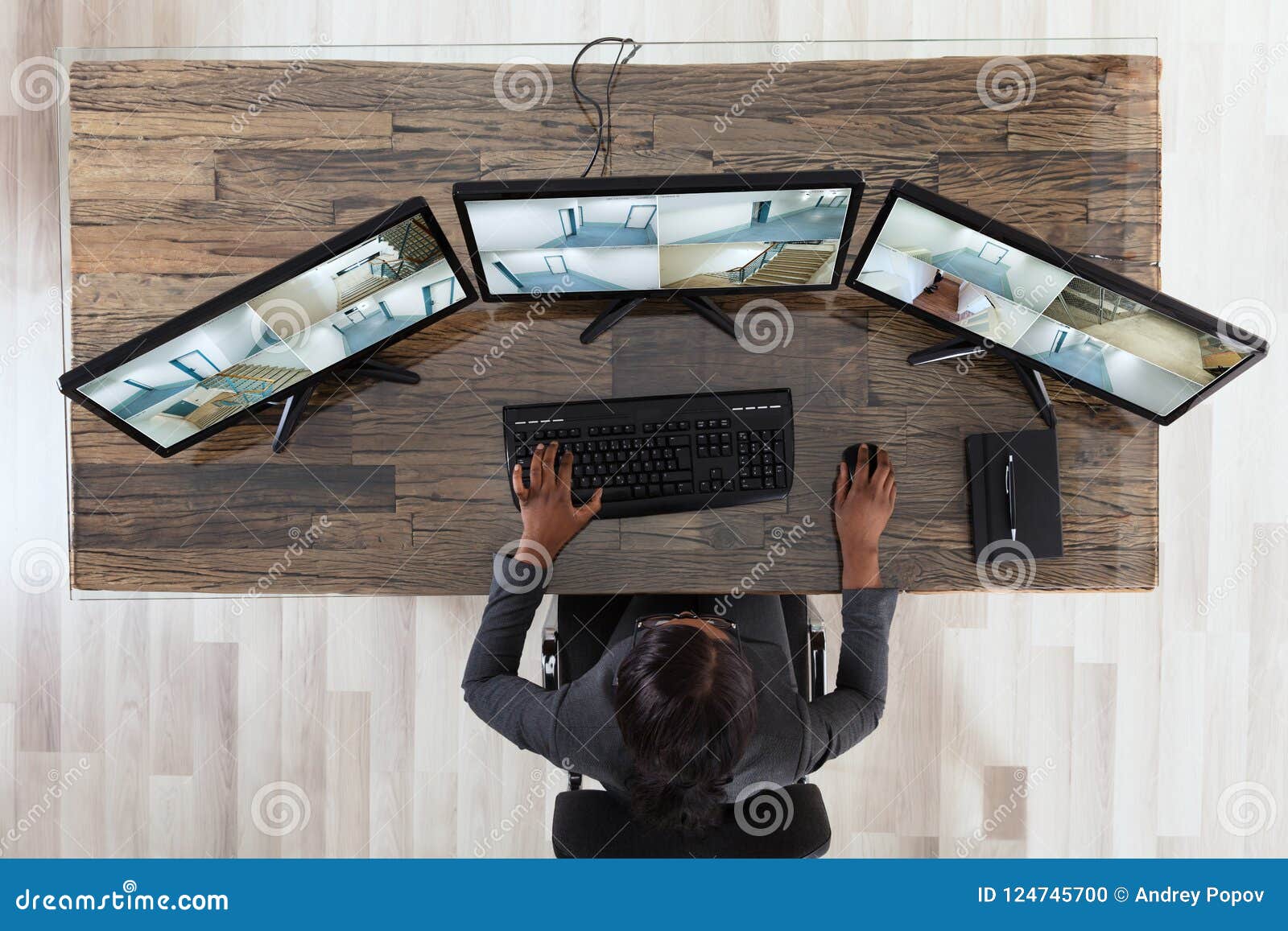 Businesswoman Looking at Multiple Camera Footage in Office Stock Photo ...