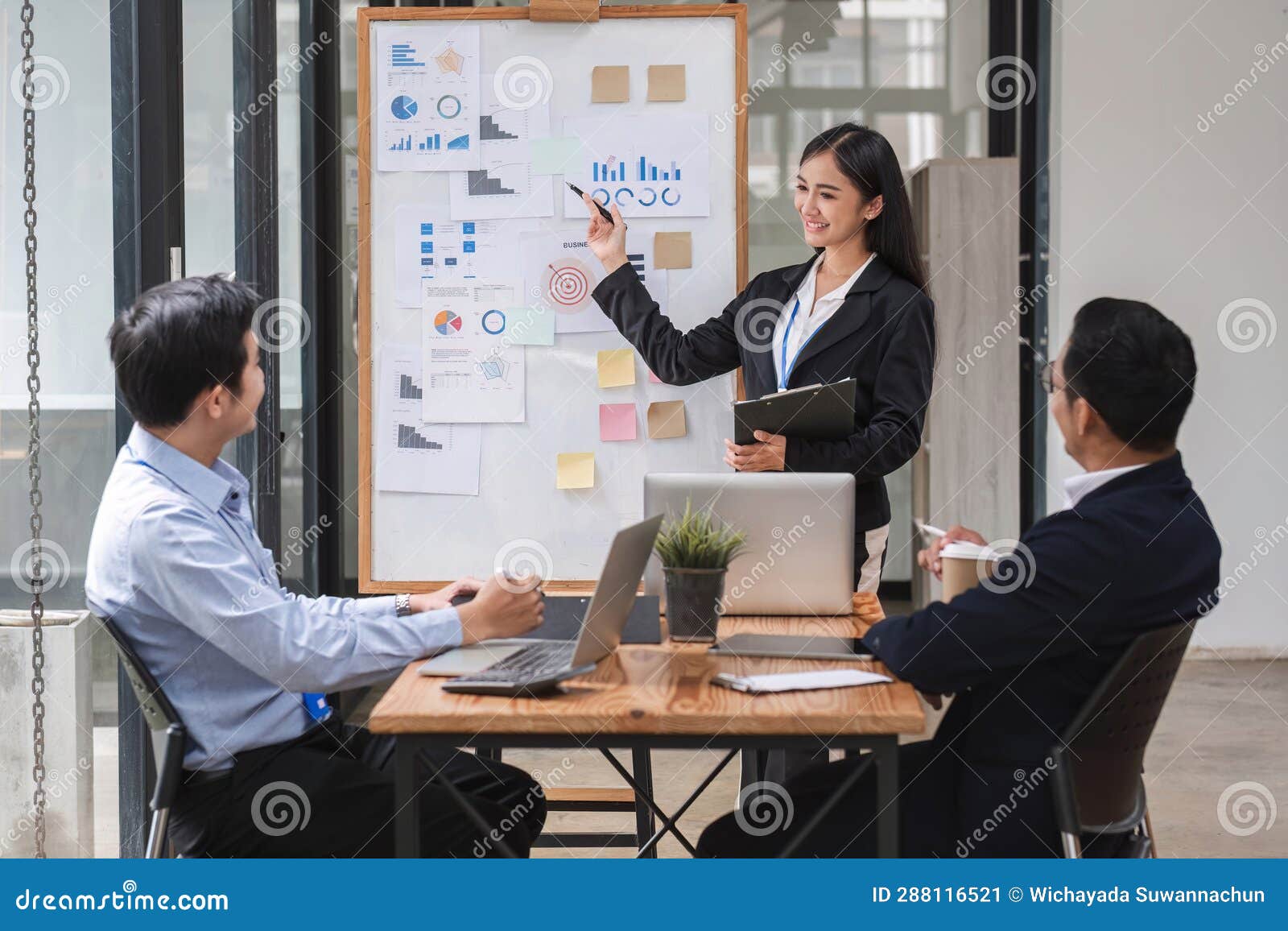 Businesswoman Presenting Data Analysis on a Board To Her Colleagues in ...