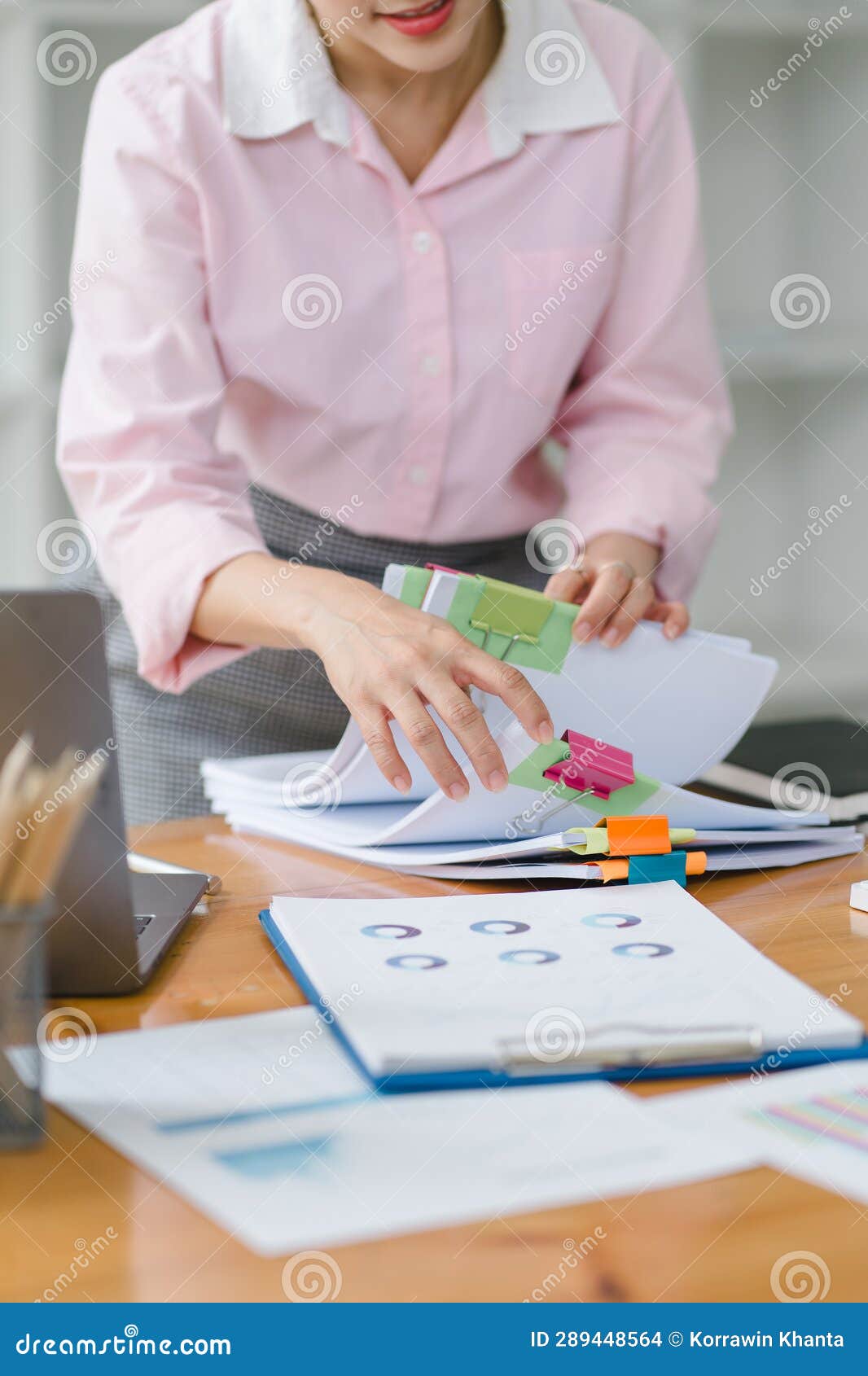 A Businesswoman is Sifting through Stacks of Paper Files and Folders ...