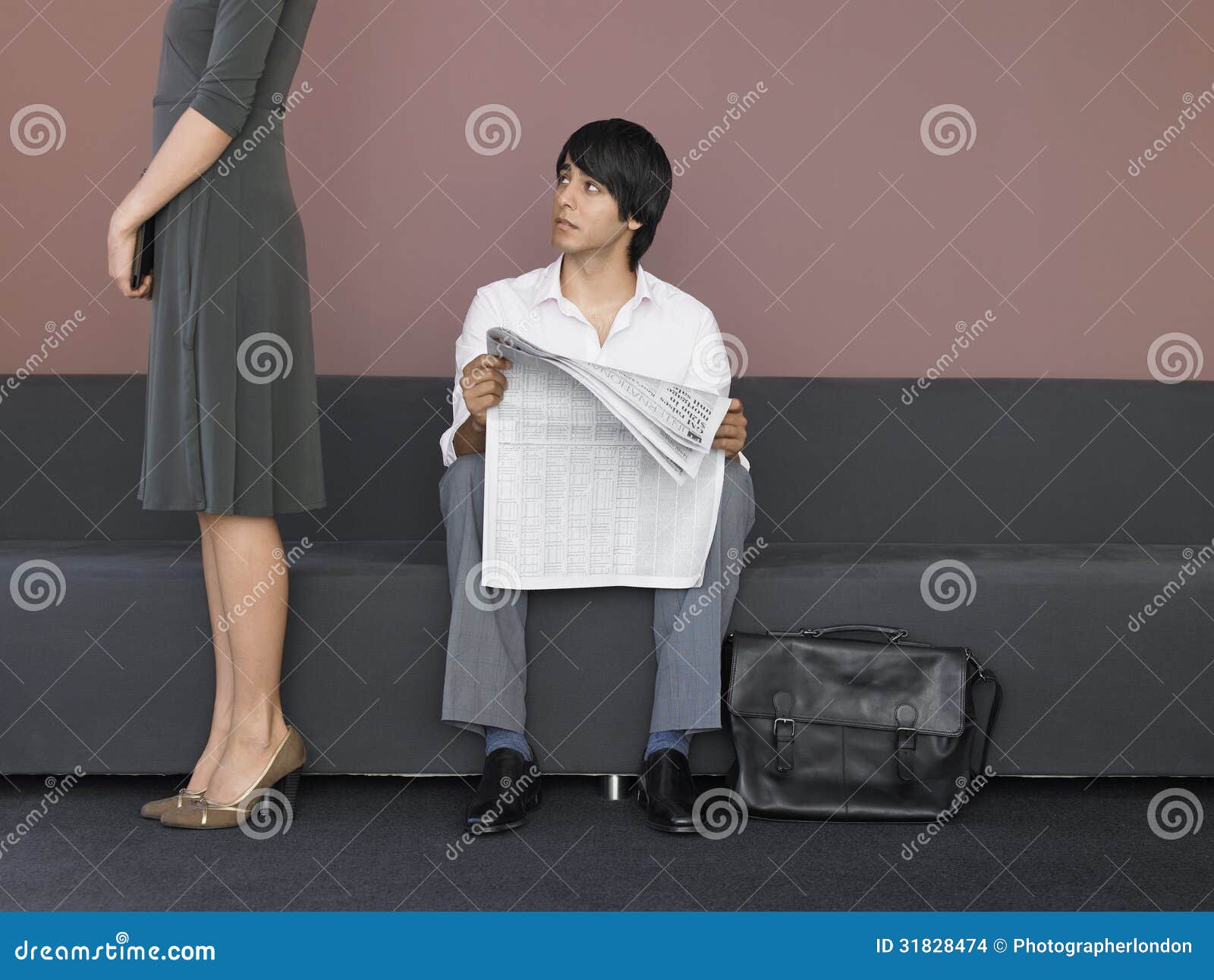 Businesswoman Standing by Businessman Reading Newspaper on Sofa Stock ... Businesswoman Standing by Businessman Reading Newspaper on Sofa Stock ...