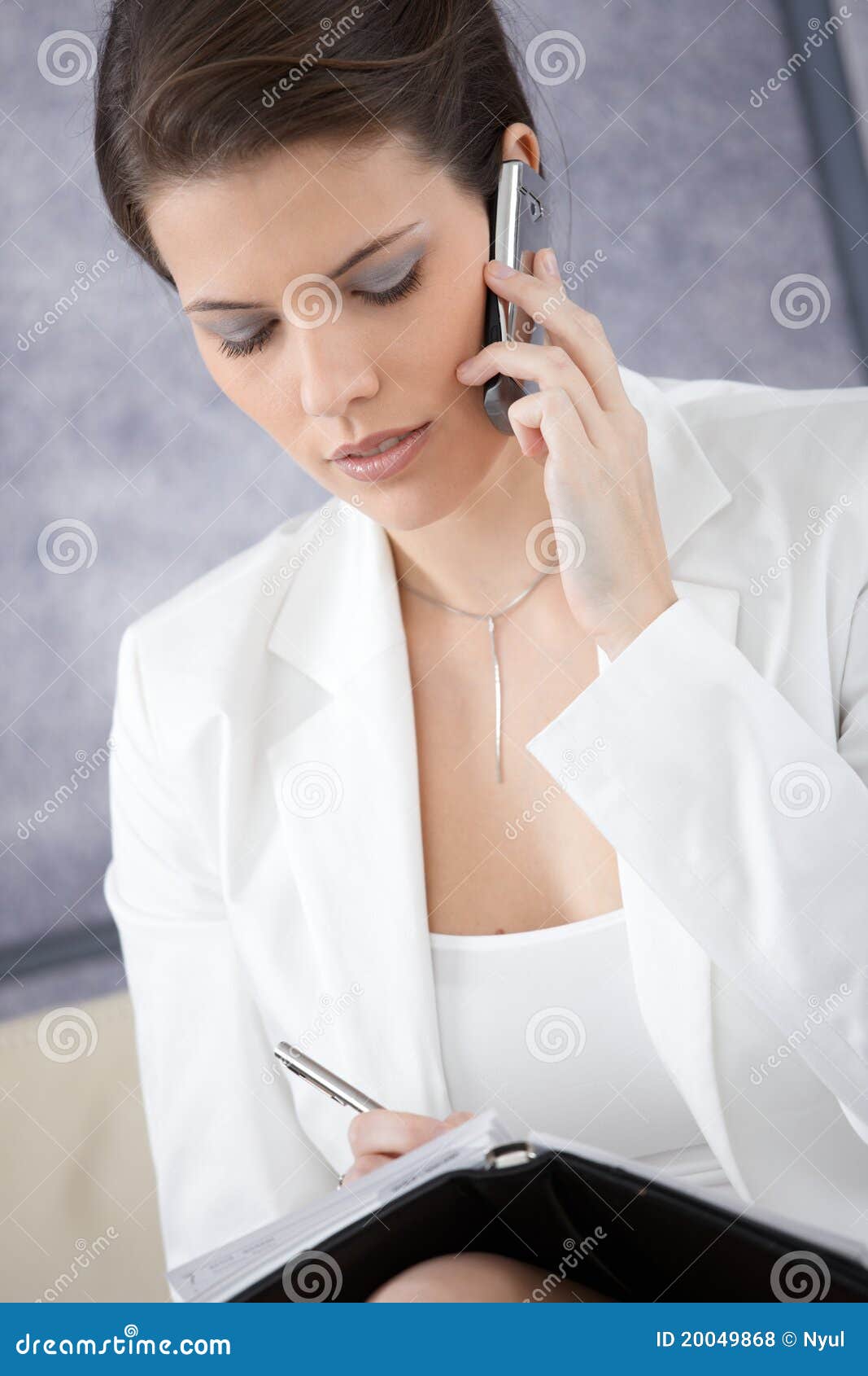 Businesswoman Taking Notes and Making Phone Call Stock Photo - Image of ...
