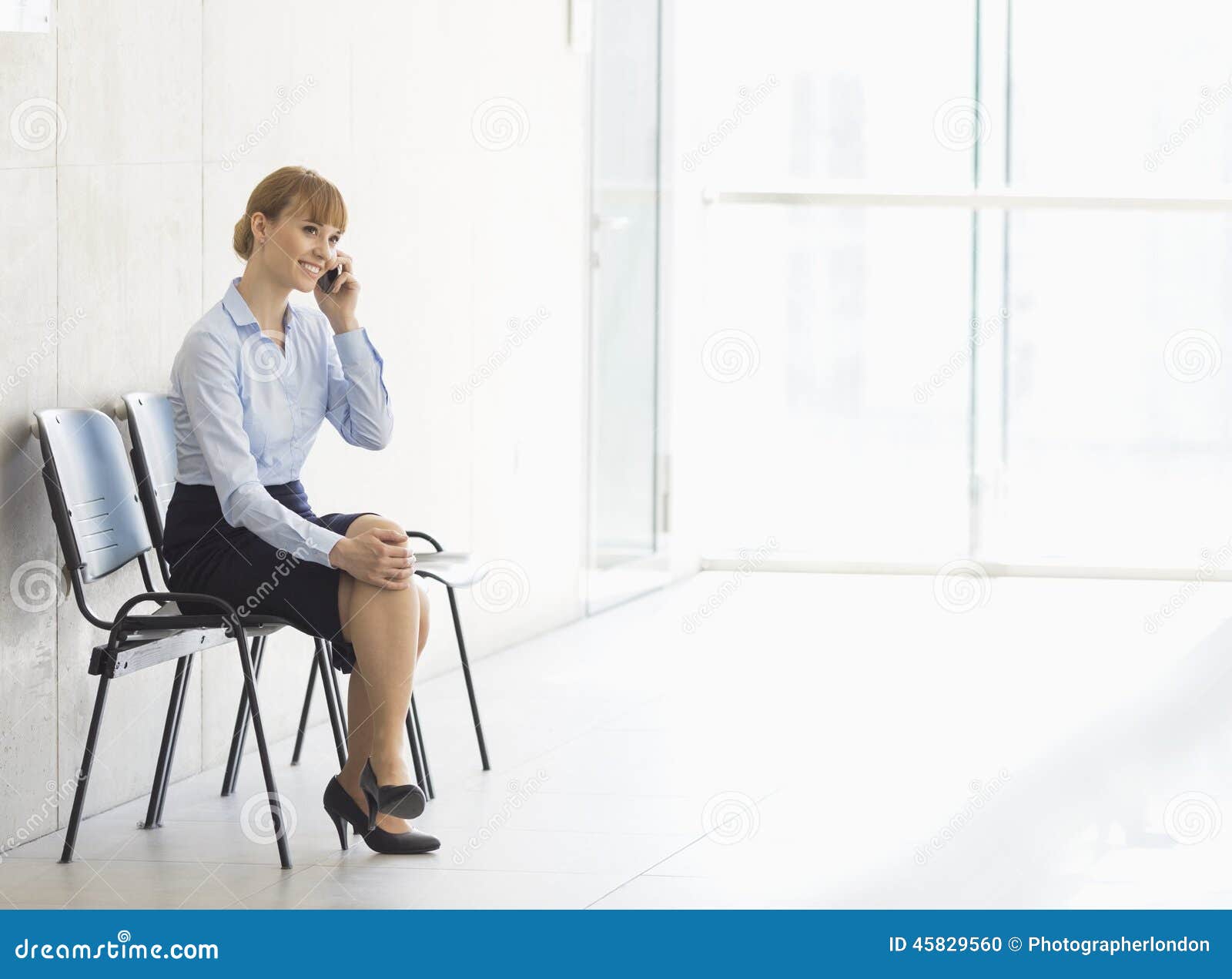 Businesswoman Using Cell Phone while Sitting on Chair in Office Stock ...